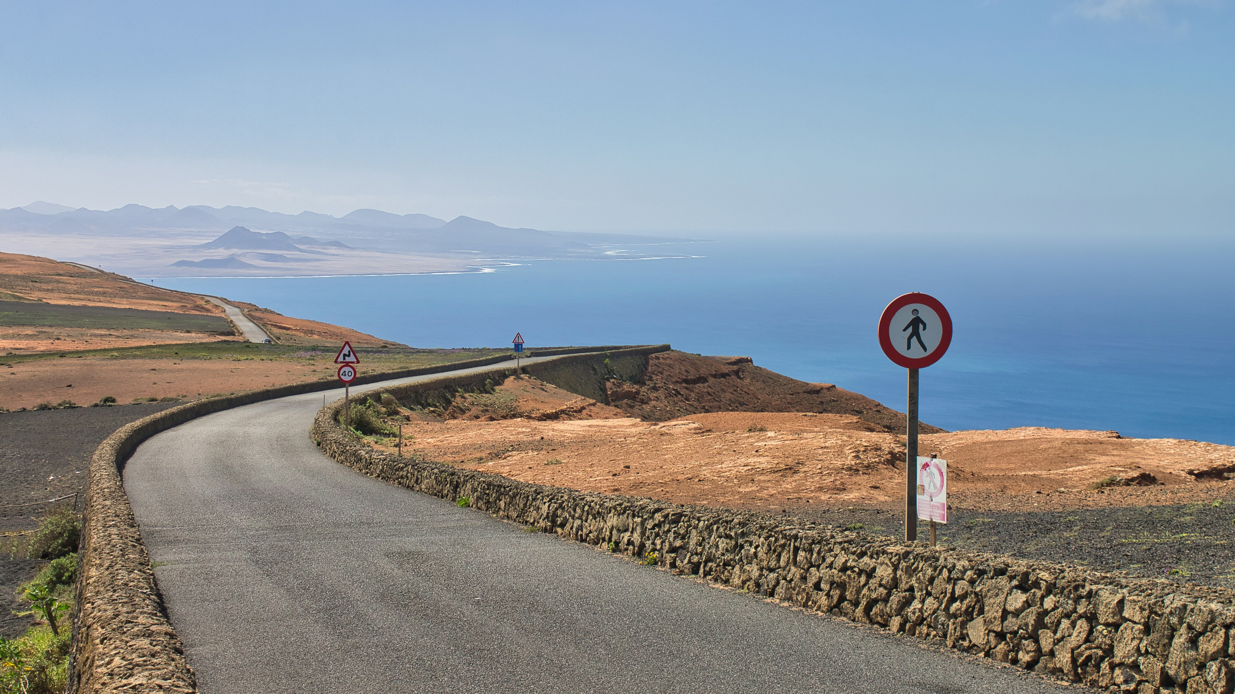 Coastline Switchback: a sunlit road hugging the cliffs toward the sea