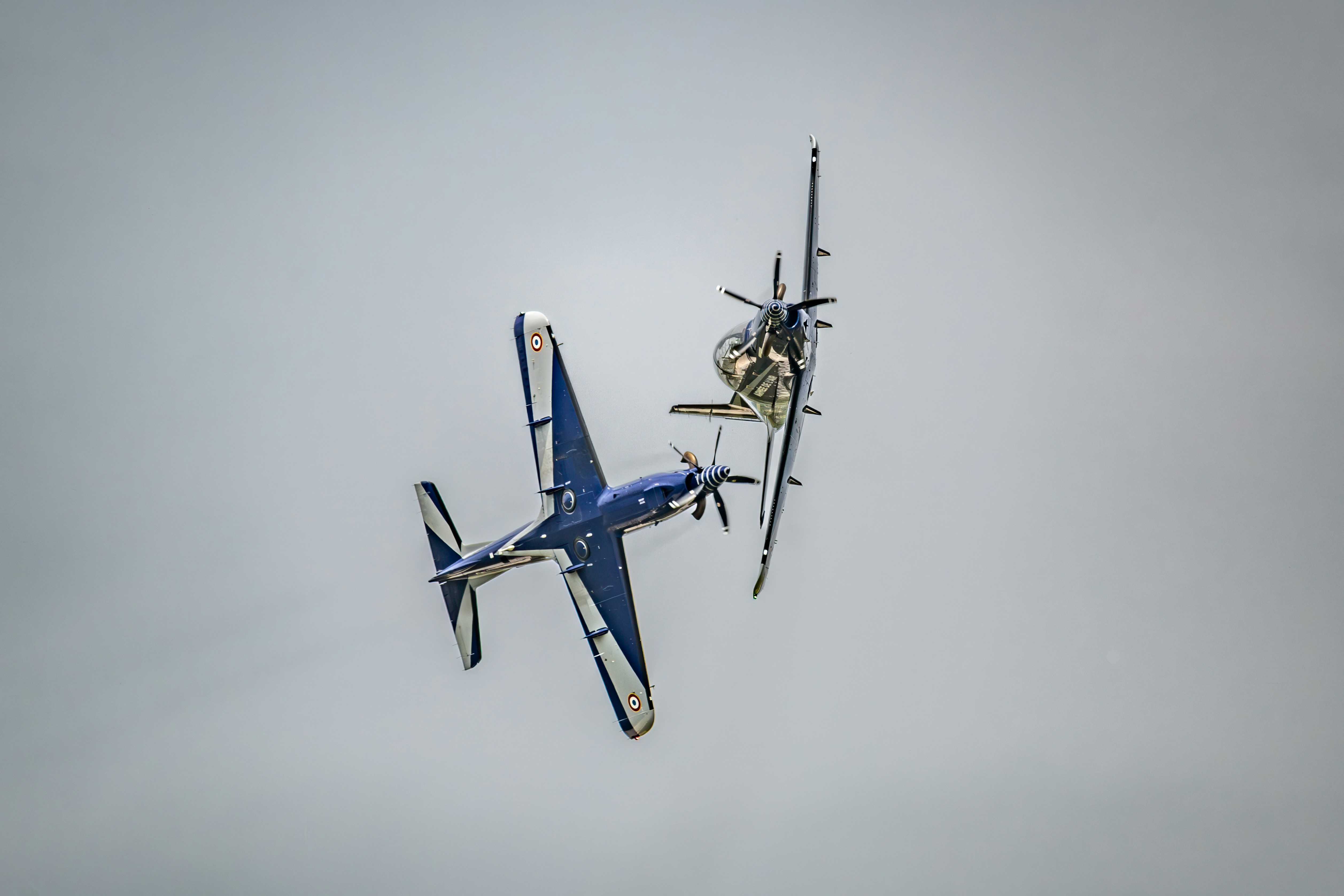 Wingtip Pas de Deux: Blue and Silver Prop Planes in a Tight Sky Pass