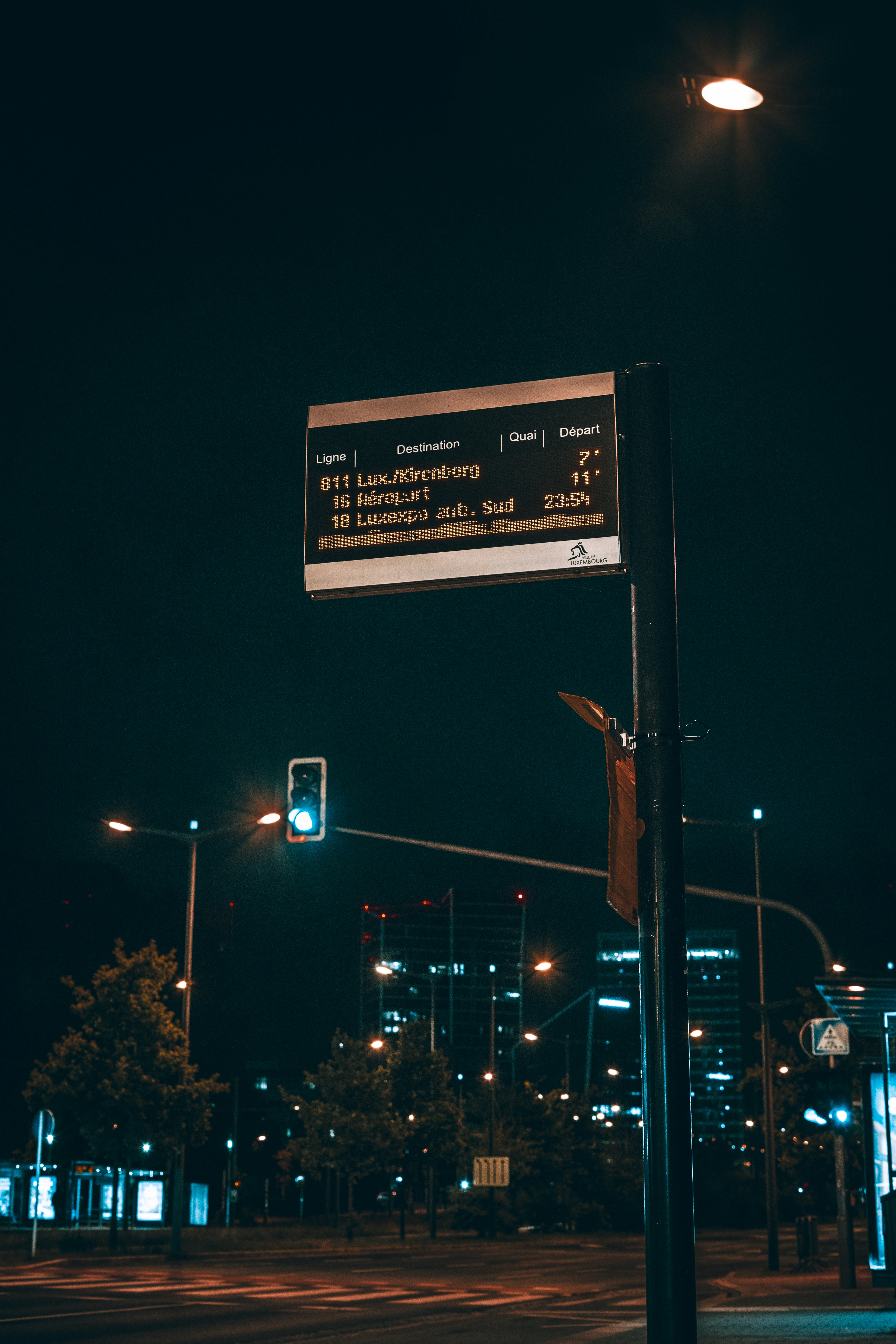 A nighttime shot of a bus stop sign.