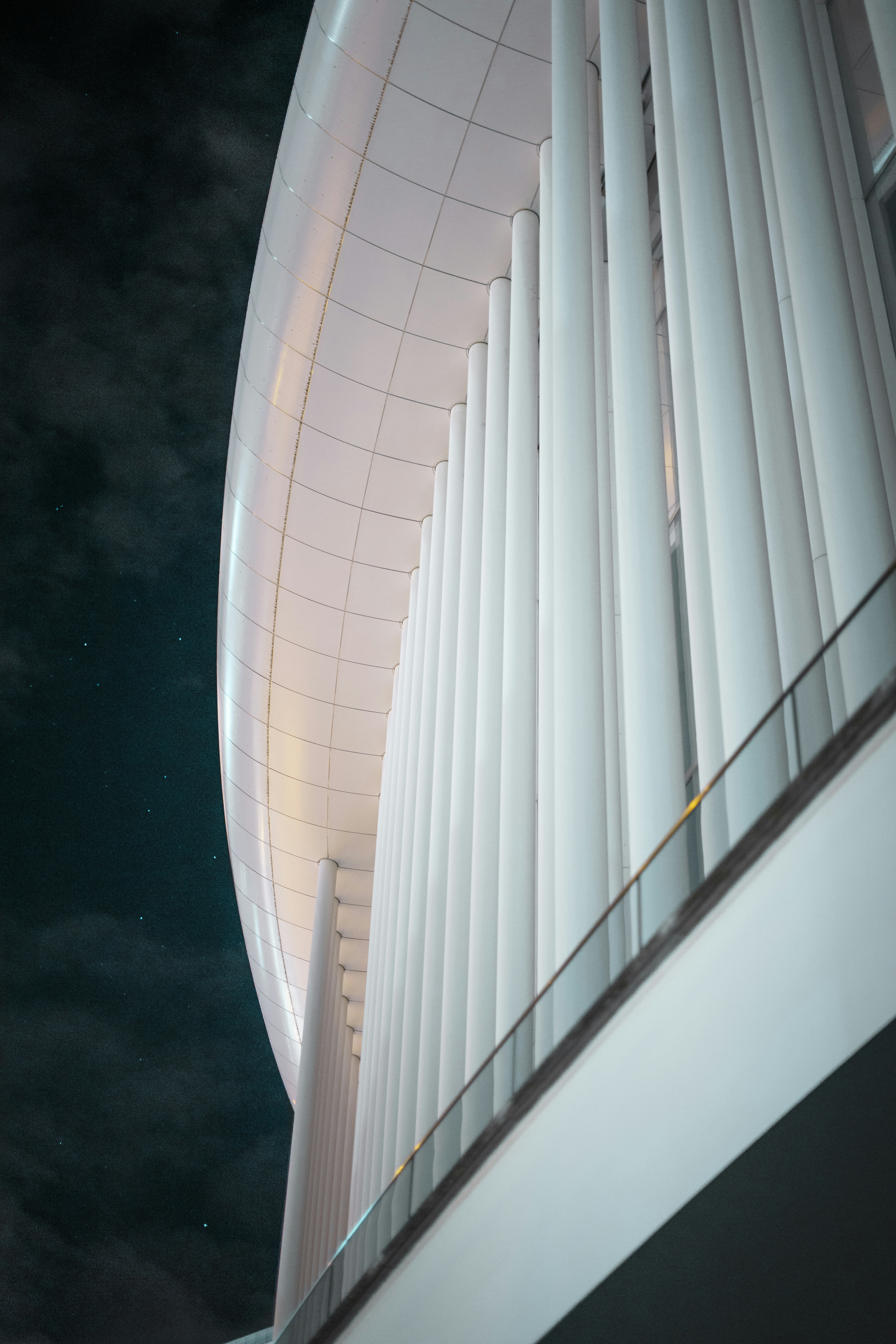 Ribbed Twilight: Nighttime Curve of a Modern Facade