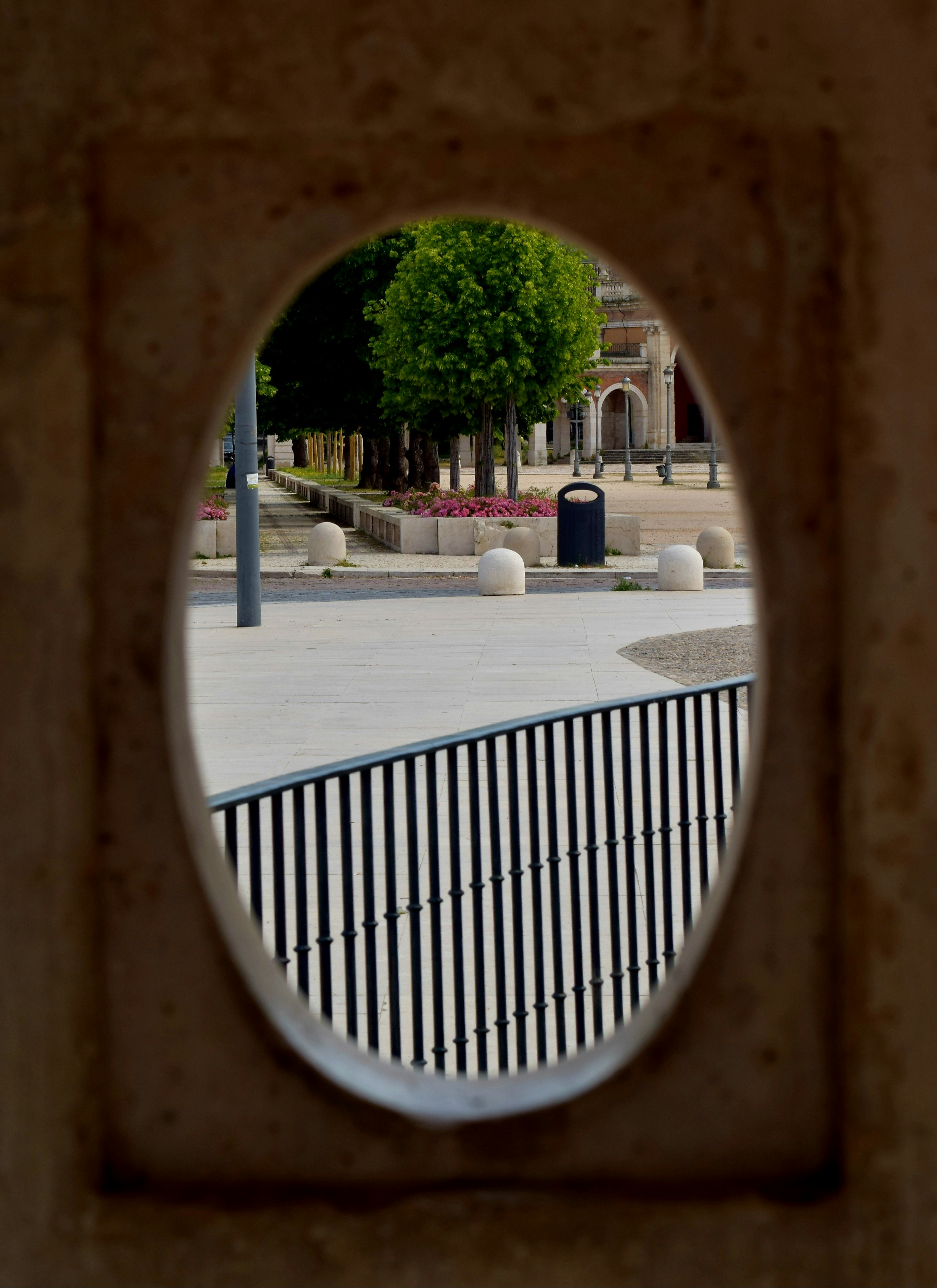 Framed City Garden: An Oval Portal to a Quiet Plaza