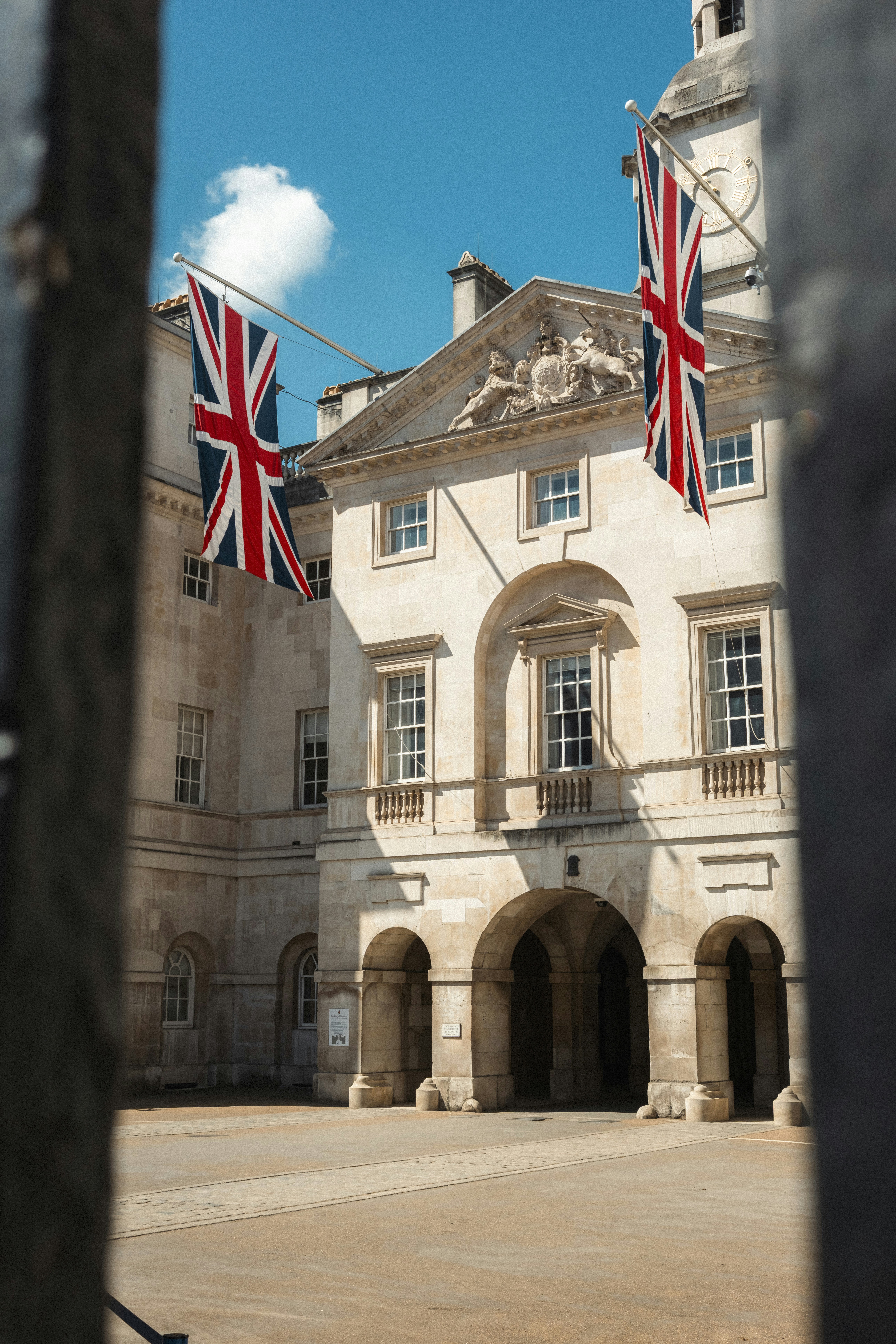UK Flagged Facade: Sunlit Town Hall Framed Between Gate Piers