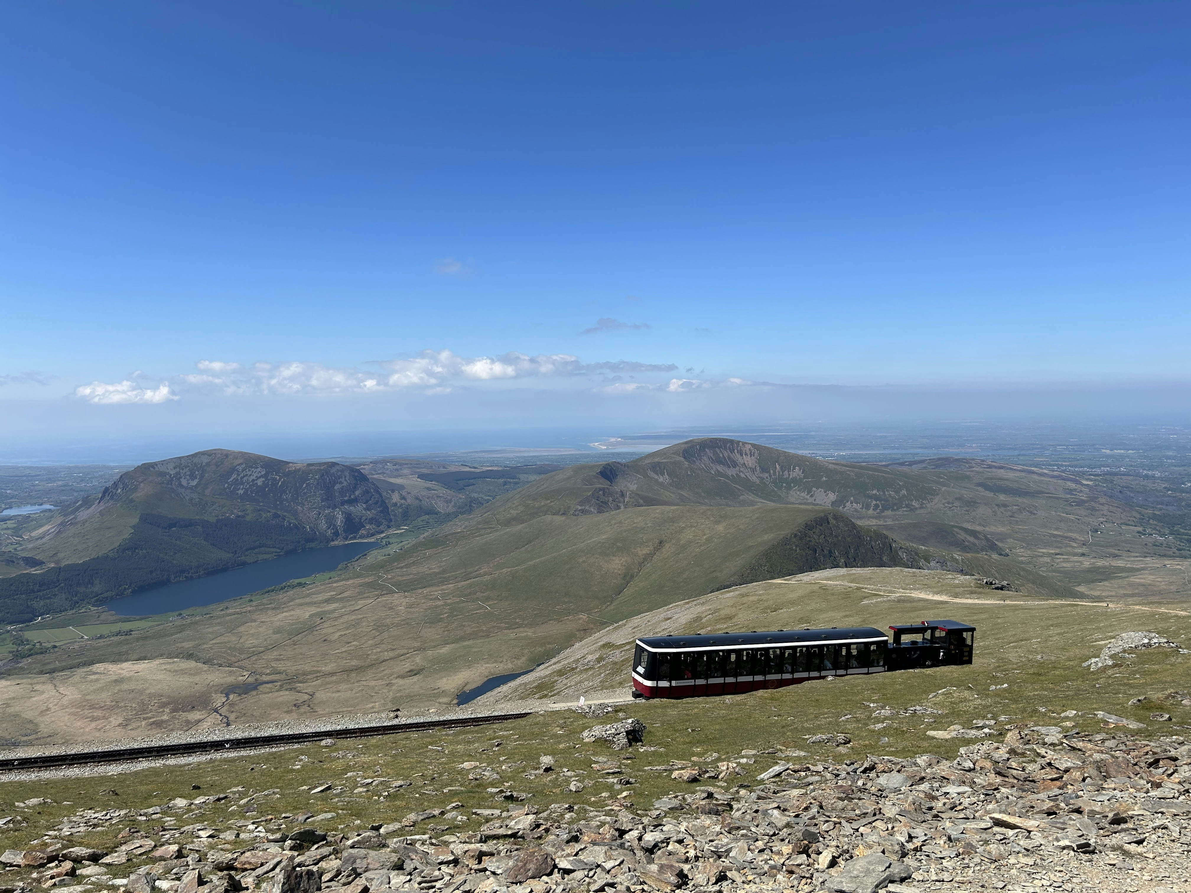 Tracks Across the Horizon: A Bus Clings to the Moor at Distant Peaks