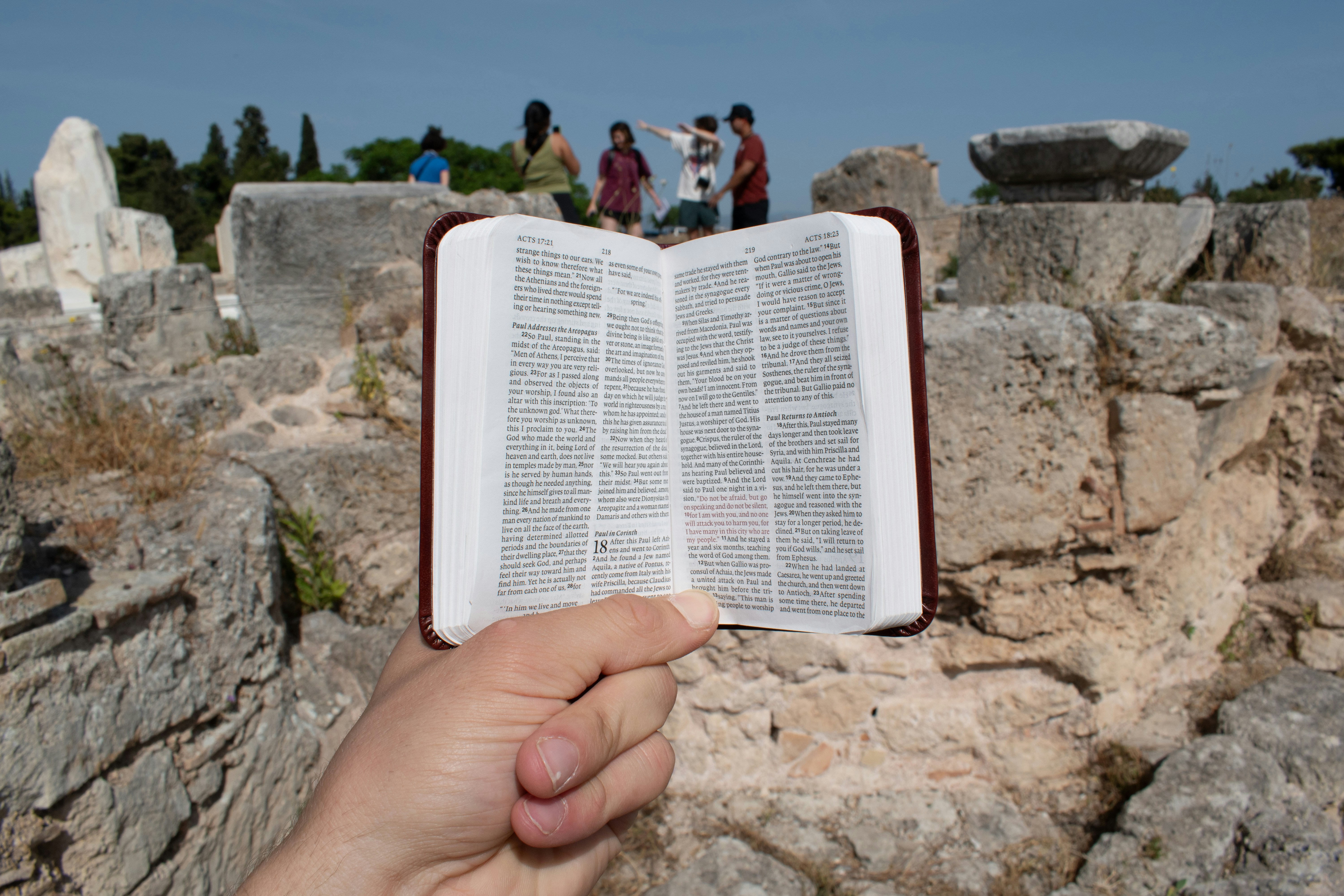 Pages in the Ruins: A Hand-Held Open Book Framing Ancient Stones