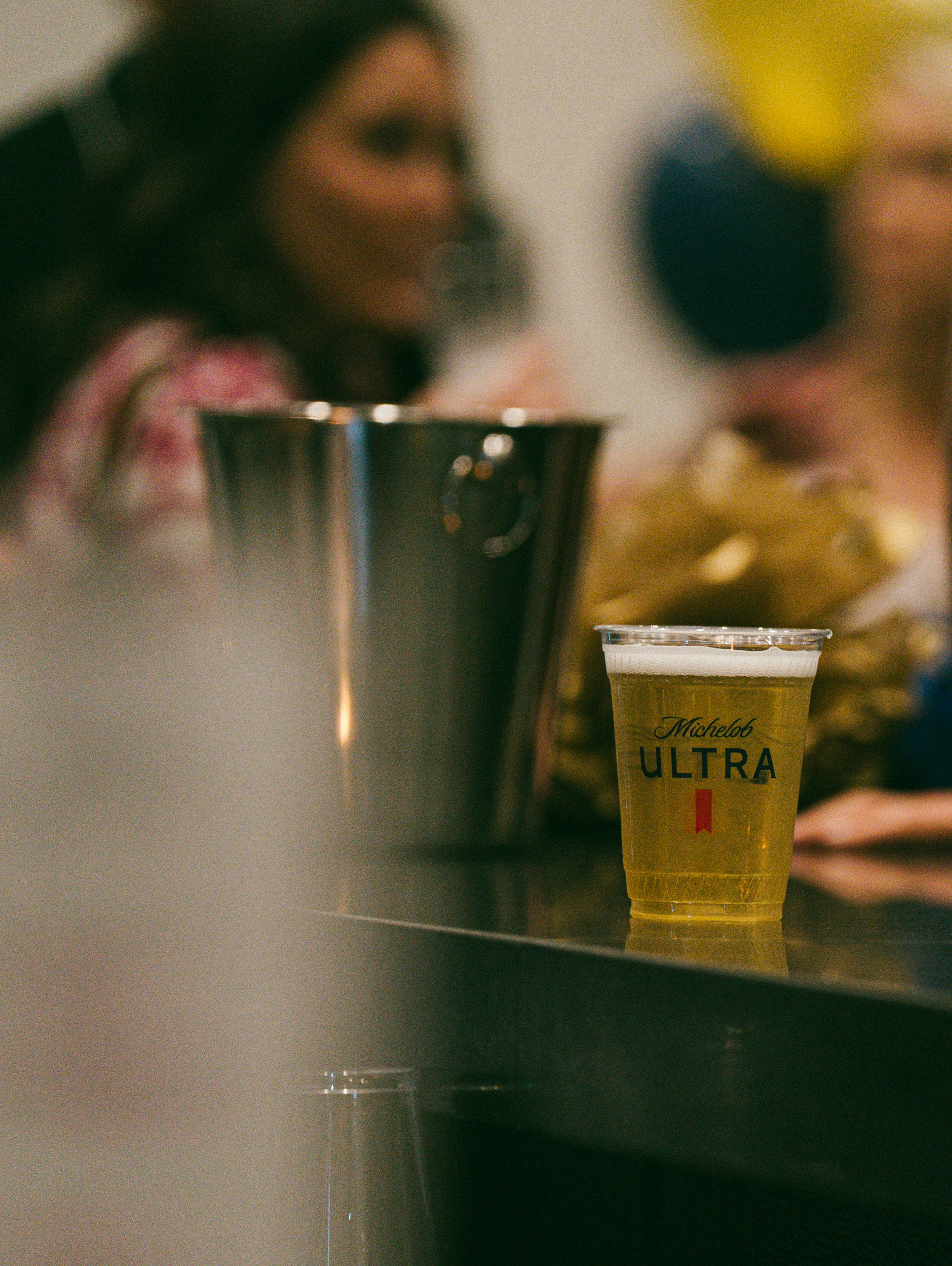 Amber Glass Under Bar Lights: A Quiet Moment Amid the Crowd