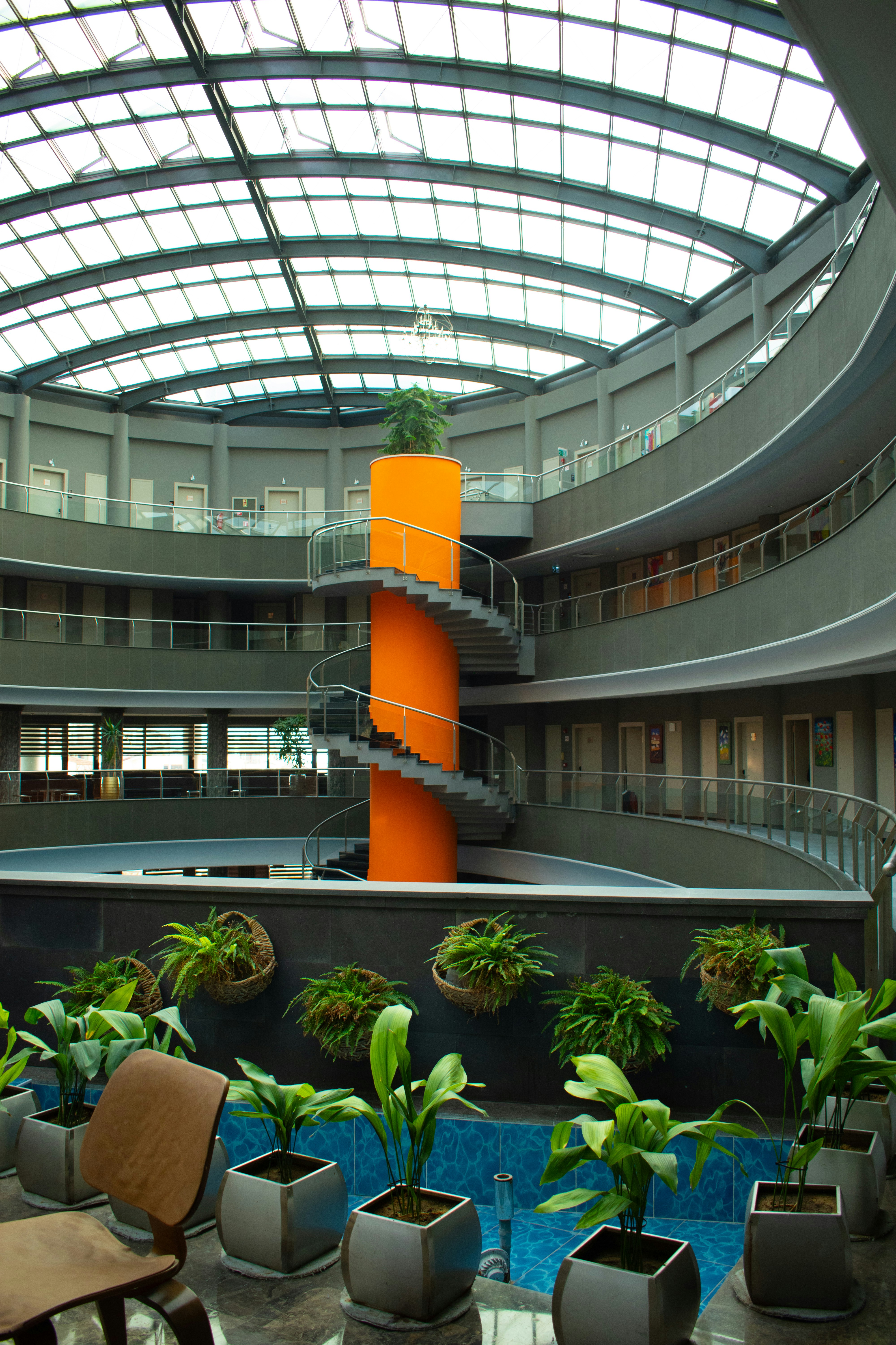 An atrium with spiral staircase and indoor plants. photo – Free ...
