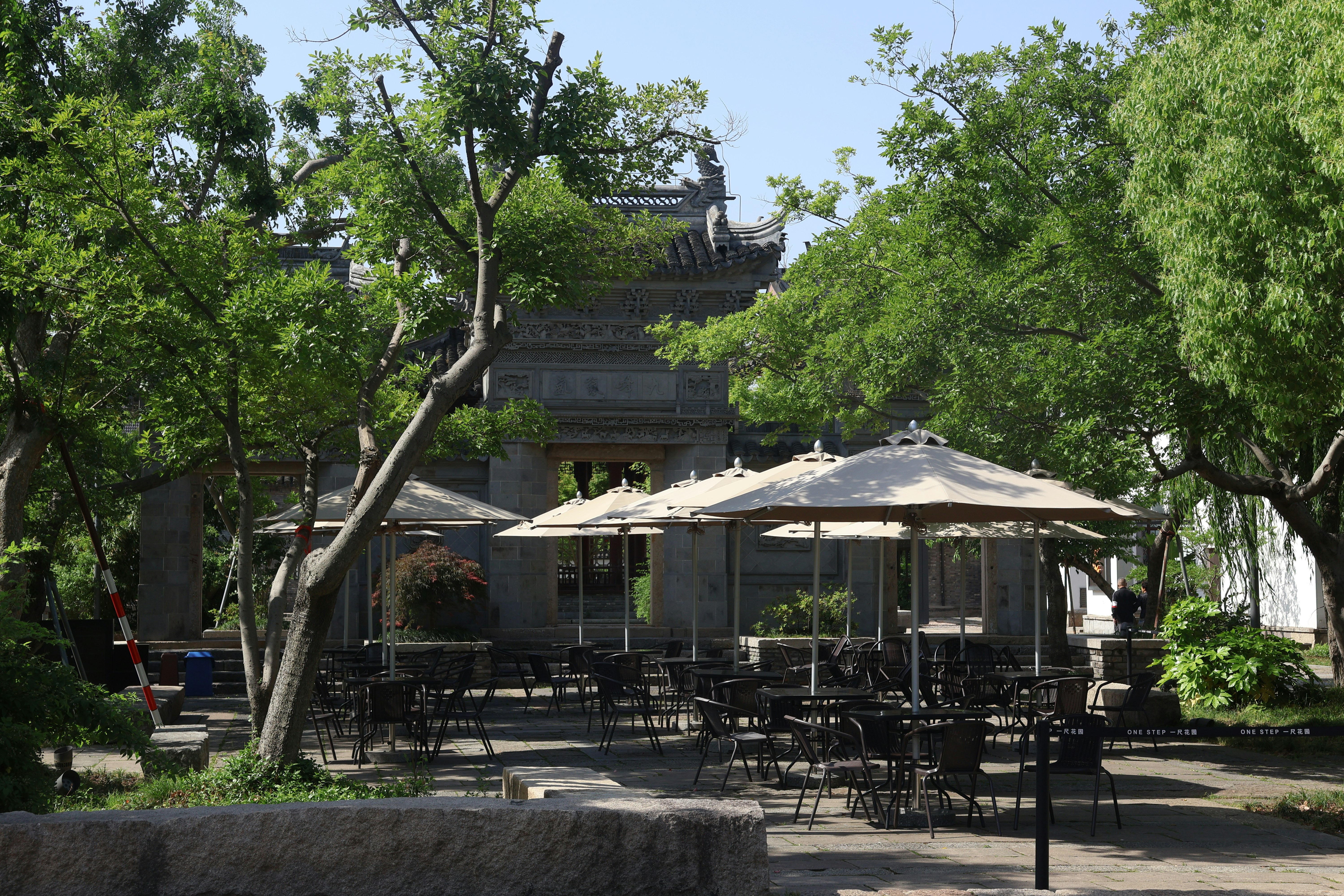 Outdoor seating with umbrellas and a building.