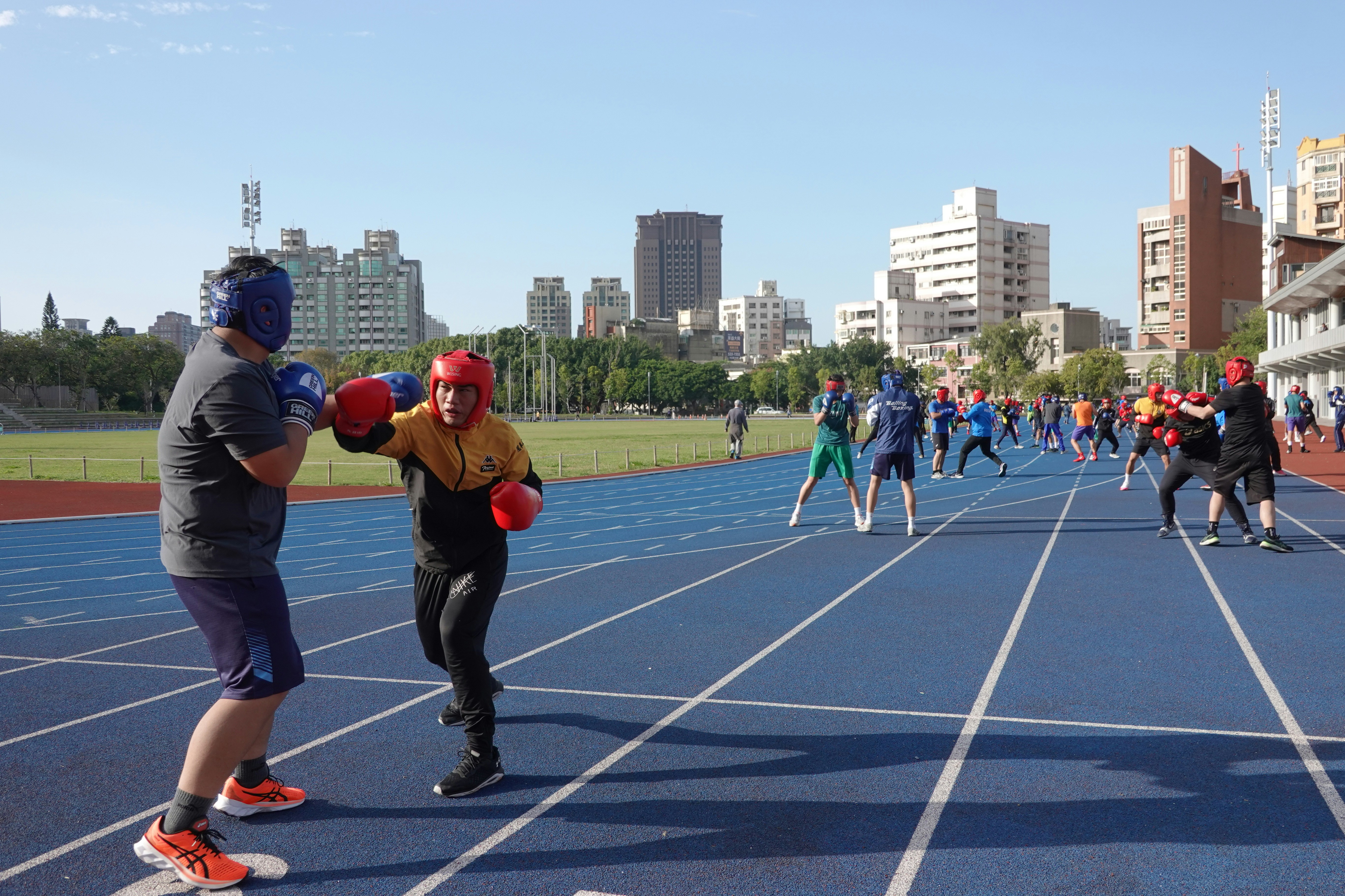 Boxers practice on a running track with others. photo – Free Man Image ...