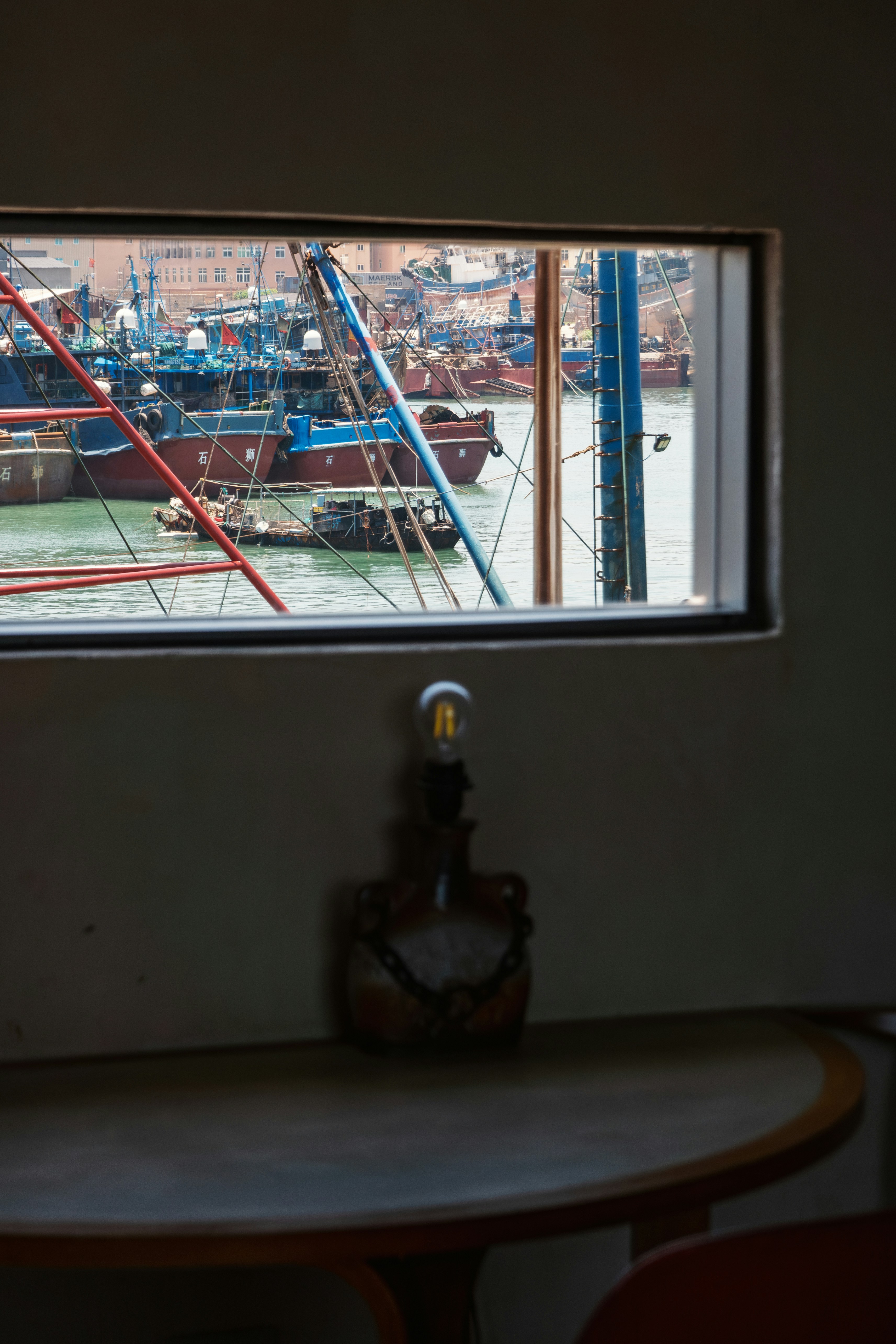 Harbor Through a Window: Boats and Rigging Framed by a Dark Portal
