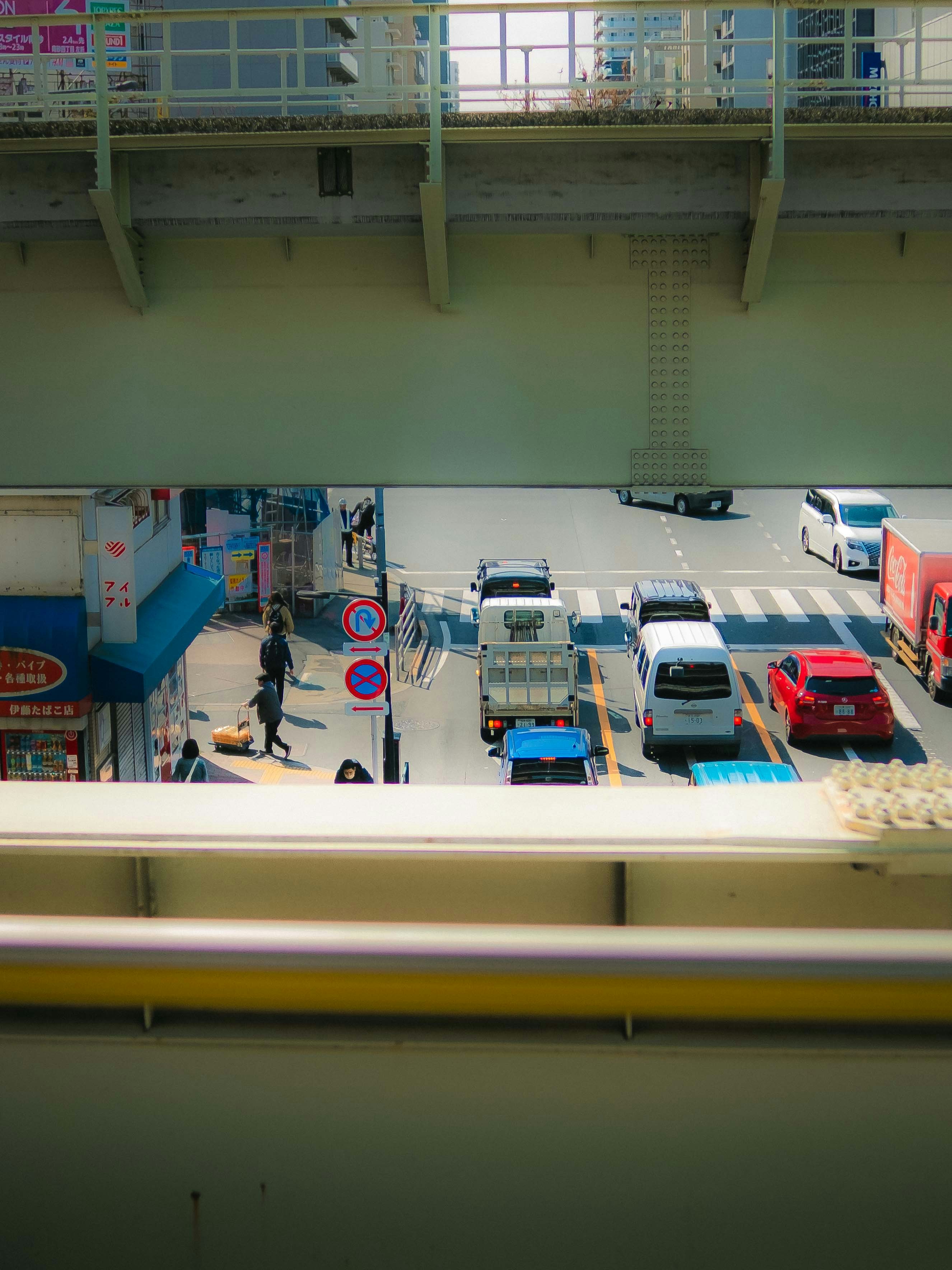 Traffic moves on a busy street below a bridge.