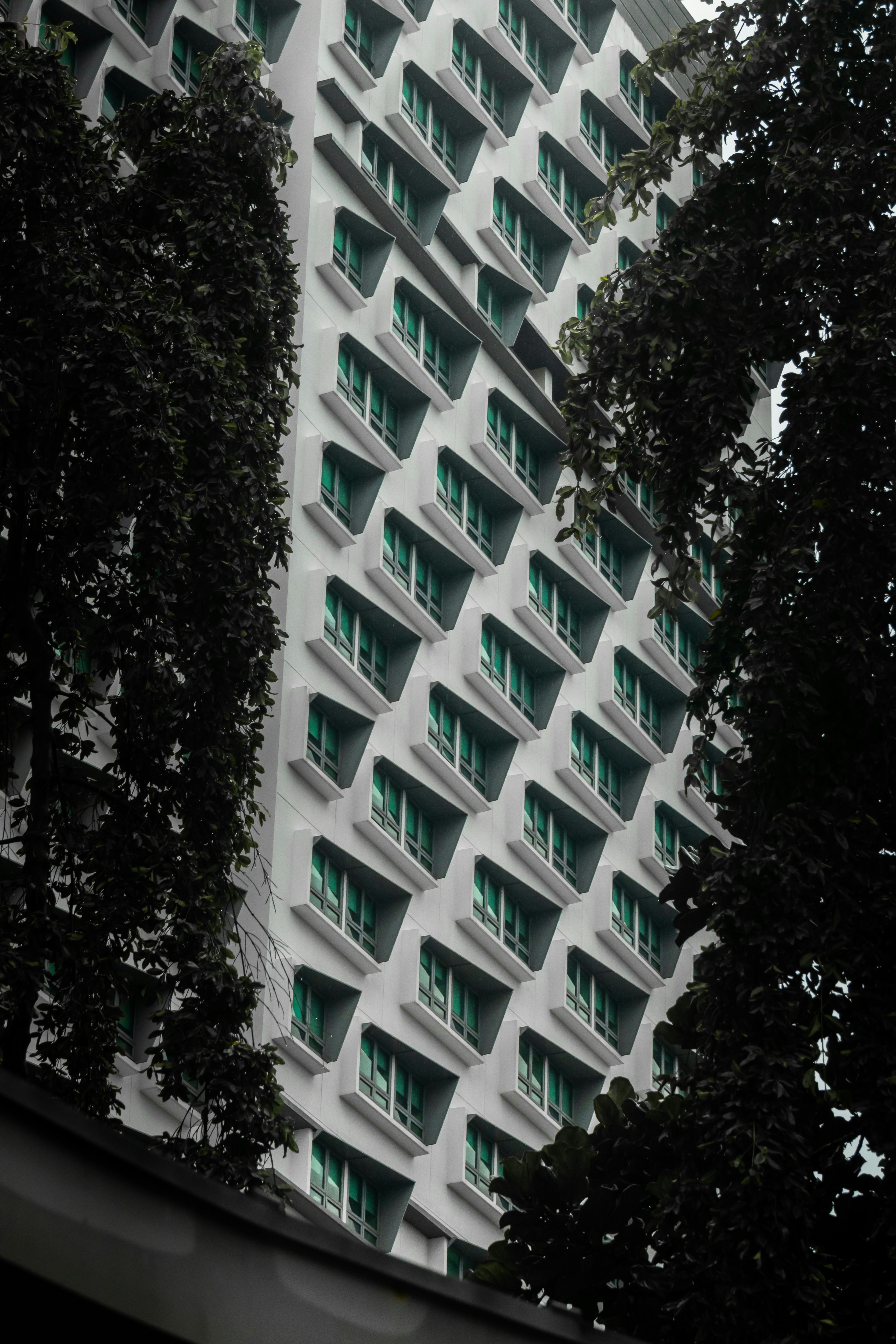 Tilted Facade: A Repeating Grid of Green-Window Balconies