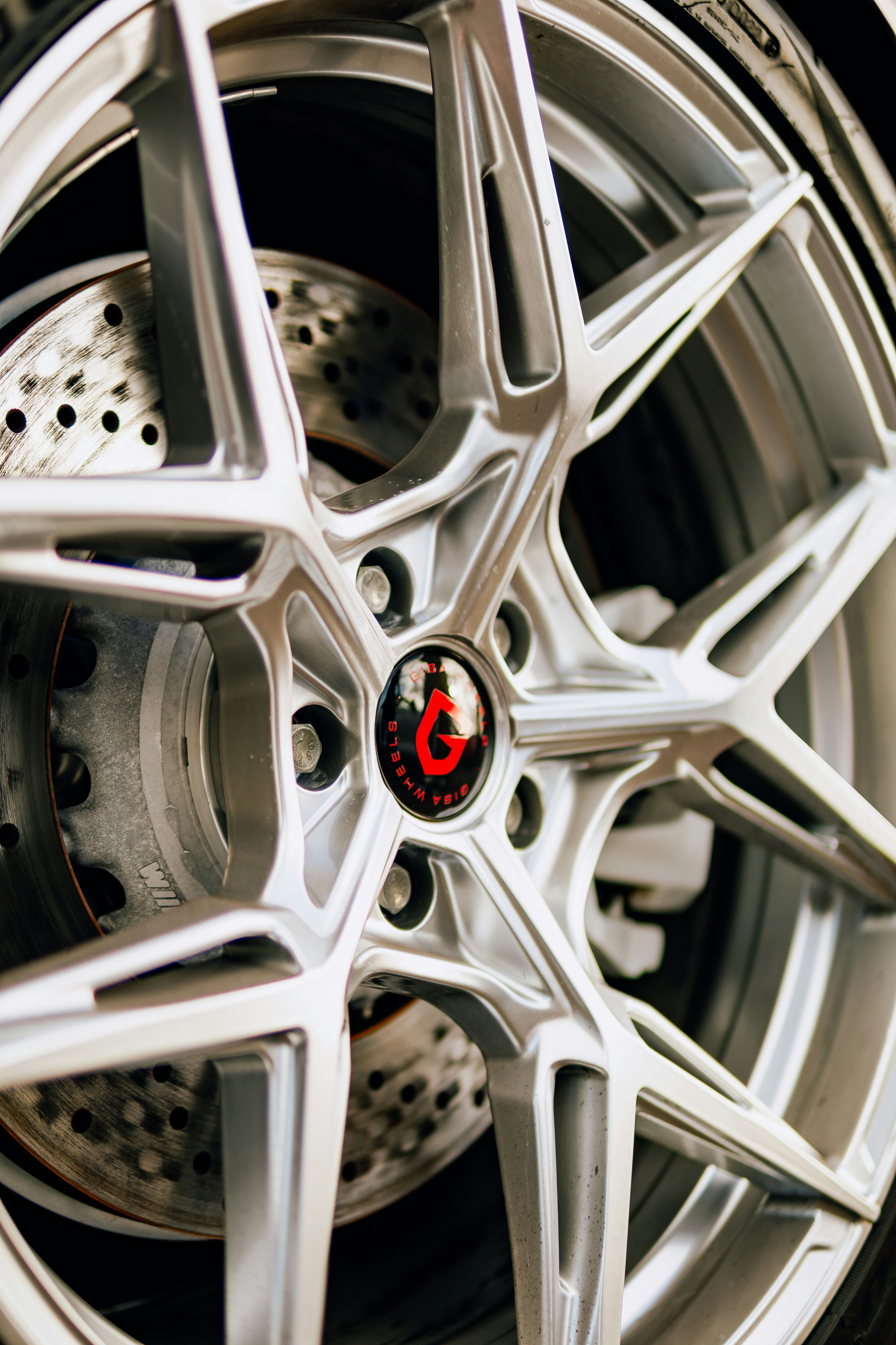 A close-up shows a shiny, stylish car wheel.