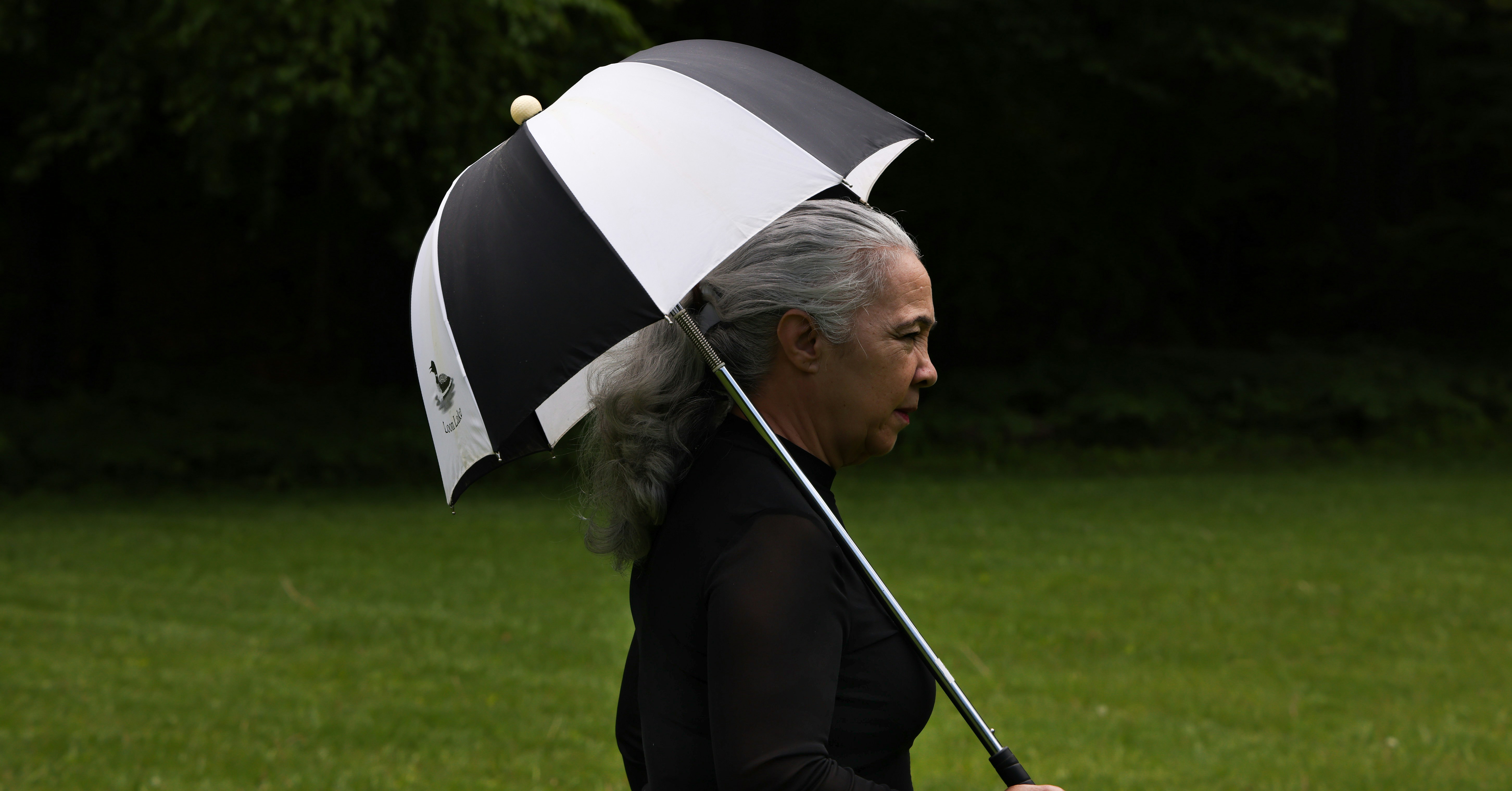 Grey-haired Umbrella Walker in a Quiet Park