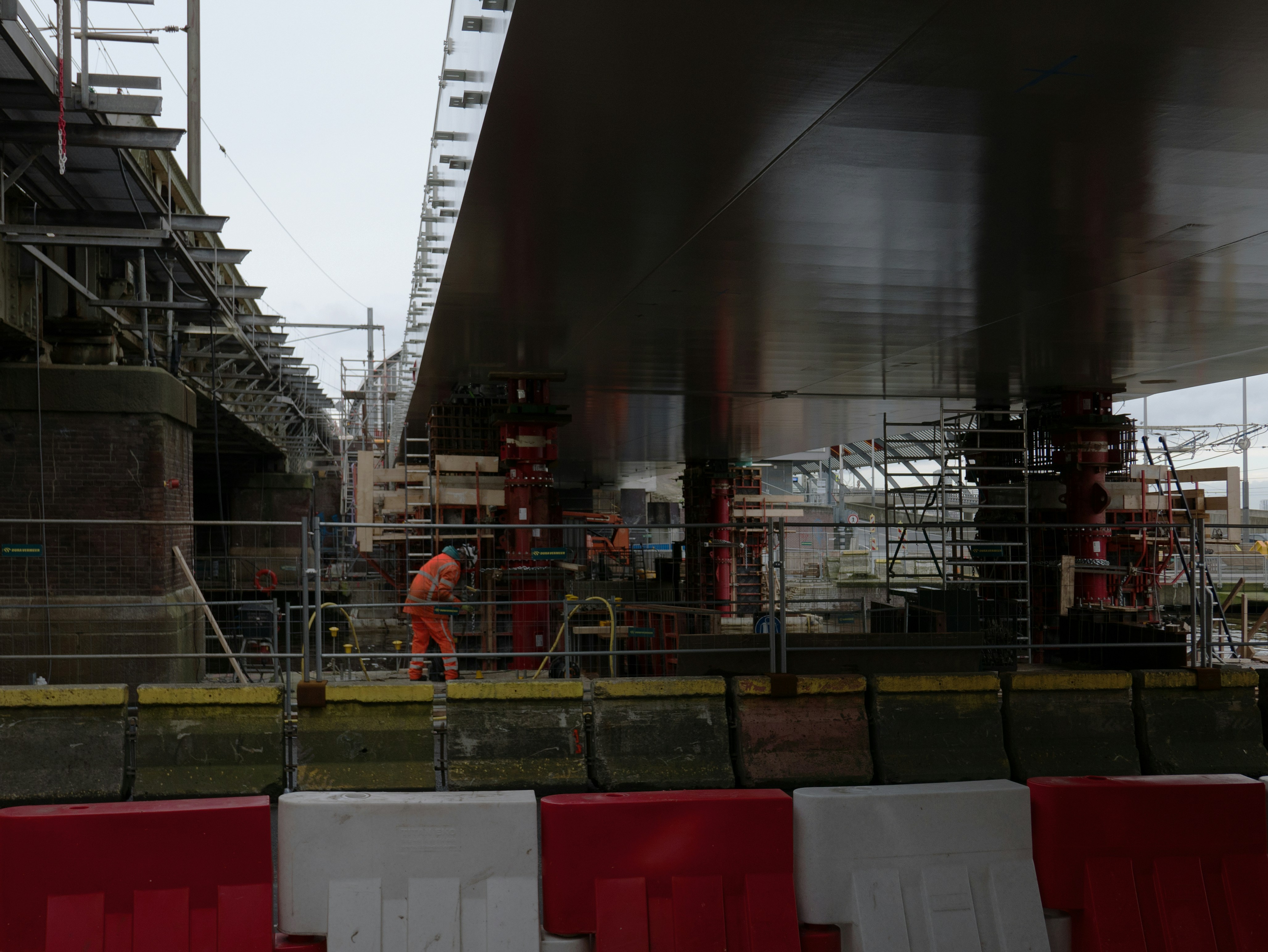 Construction workers work under a large bridge. photo – Free Free ...