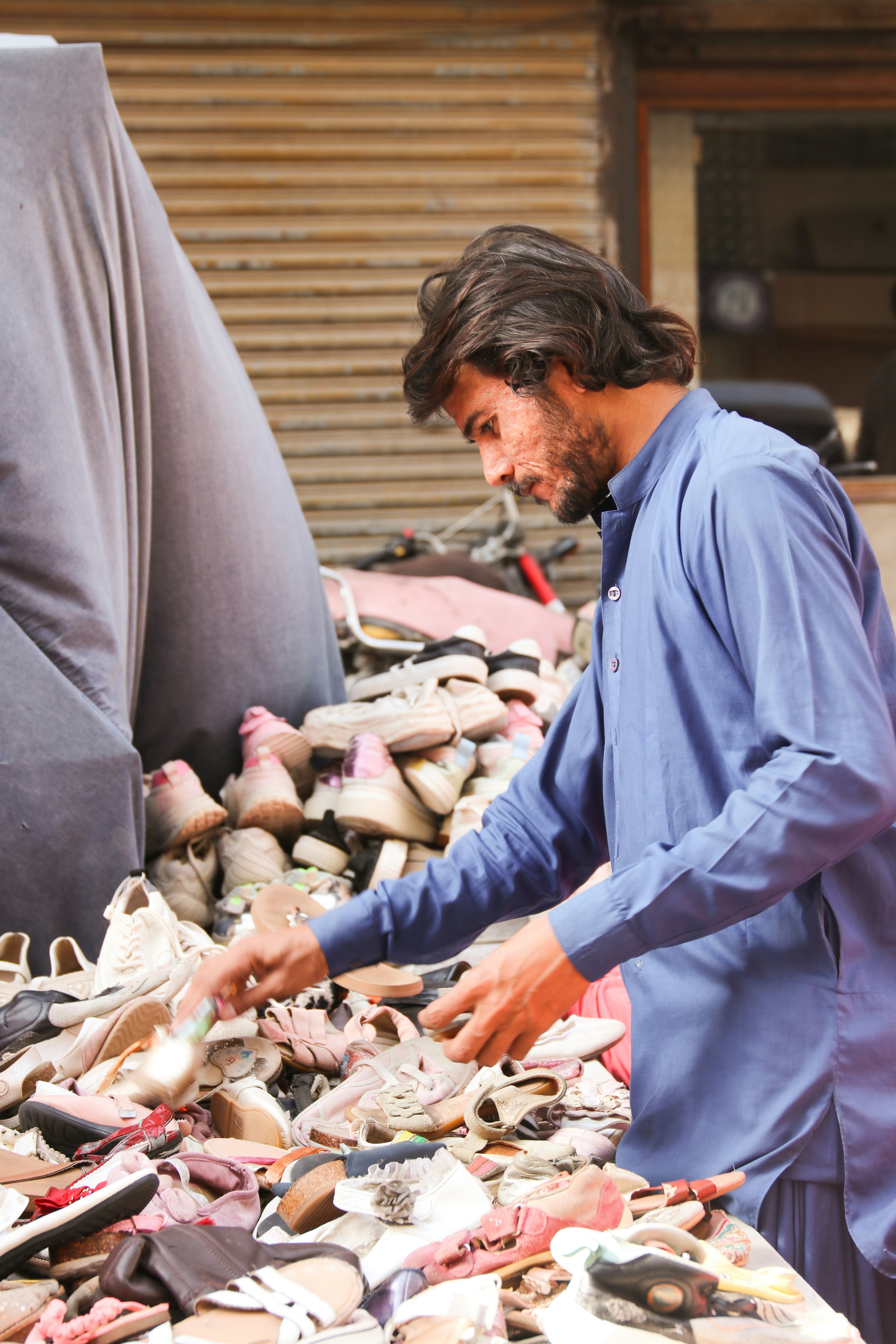 Hands in Motion: A Shoemaker’s Focus Among a Sea of Shoes