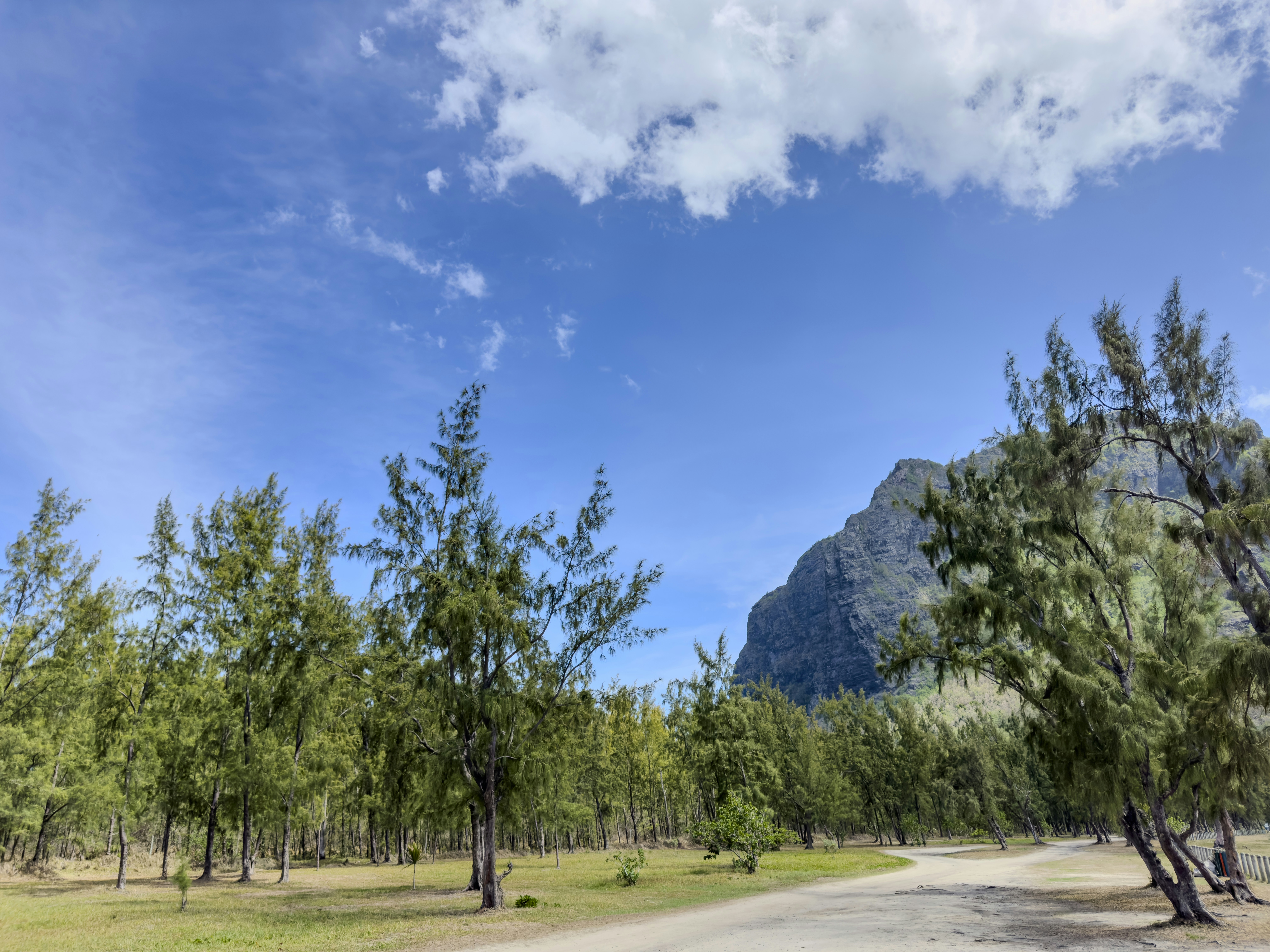 Dirt Path Winding Toward a Distant Crag Under a Clear Blue Sky
