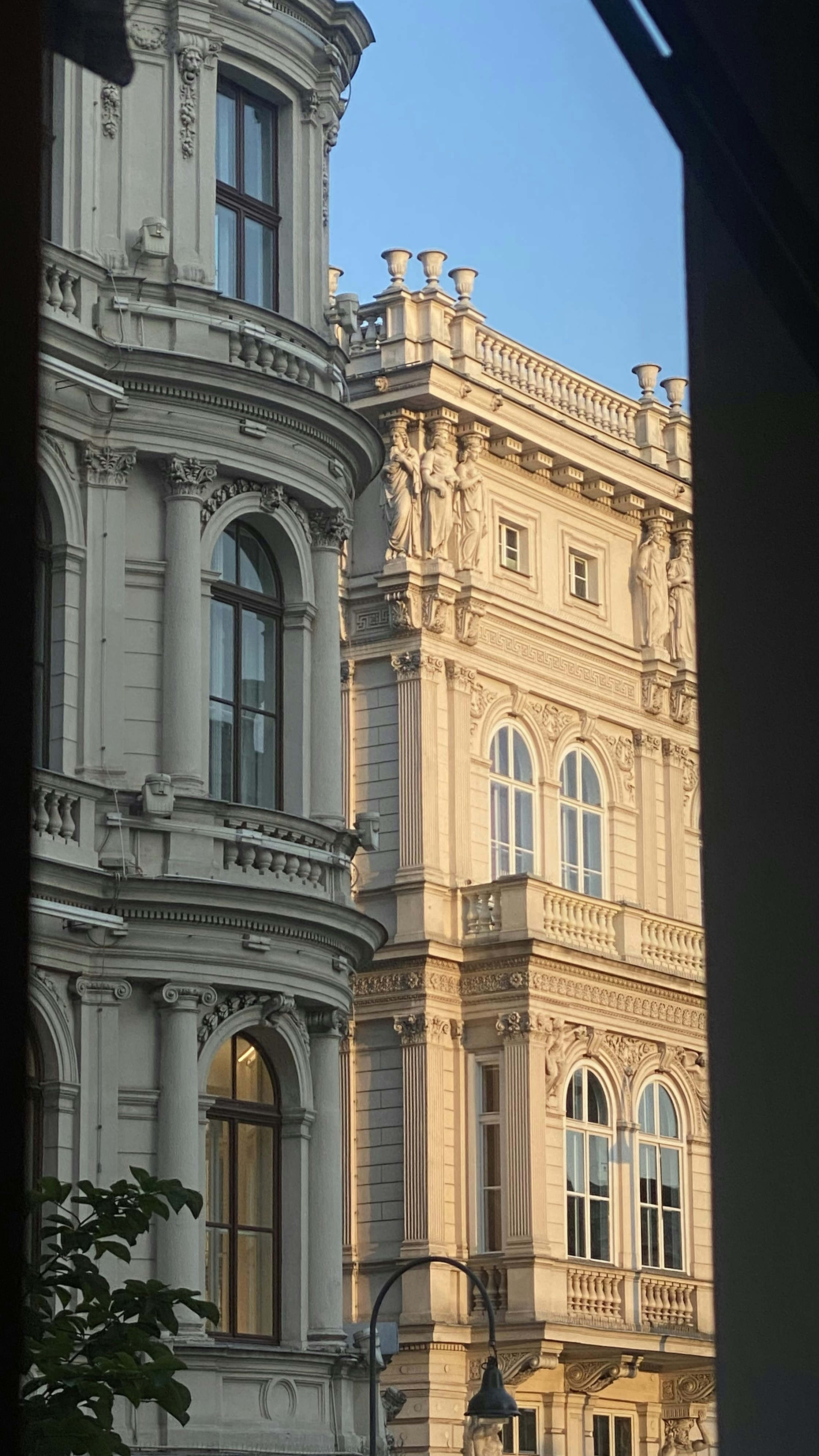 Golden Hour on Ornate Facades: Sunlit Details Through a Narrow Window