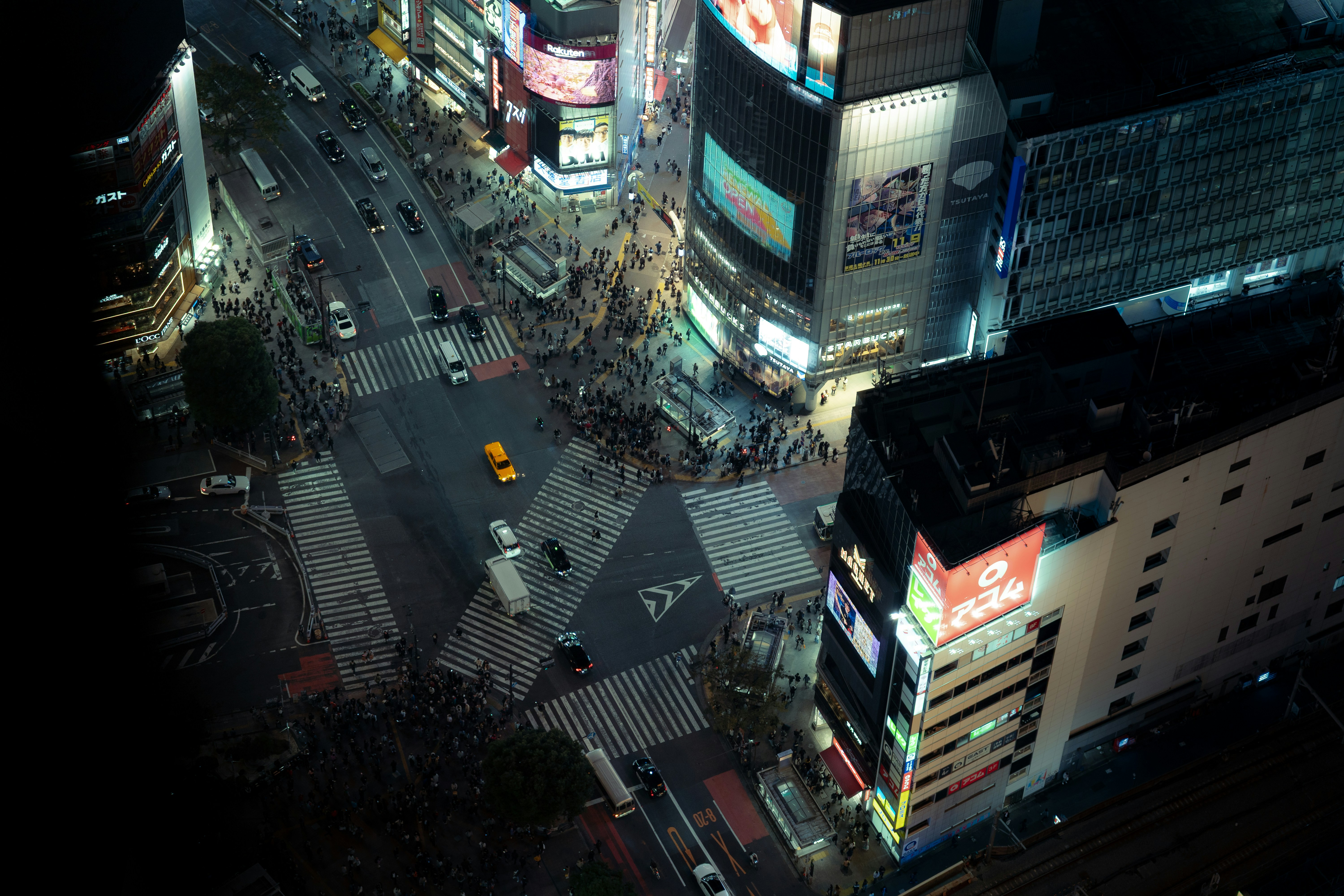 Cars crossing in Shibuya crossing in Tokyo Japan. | Nighttime aerial view of a busy tokyo intersection.