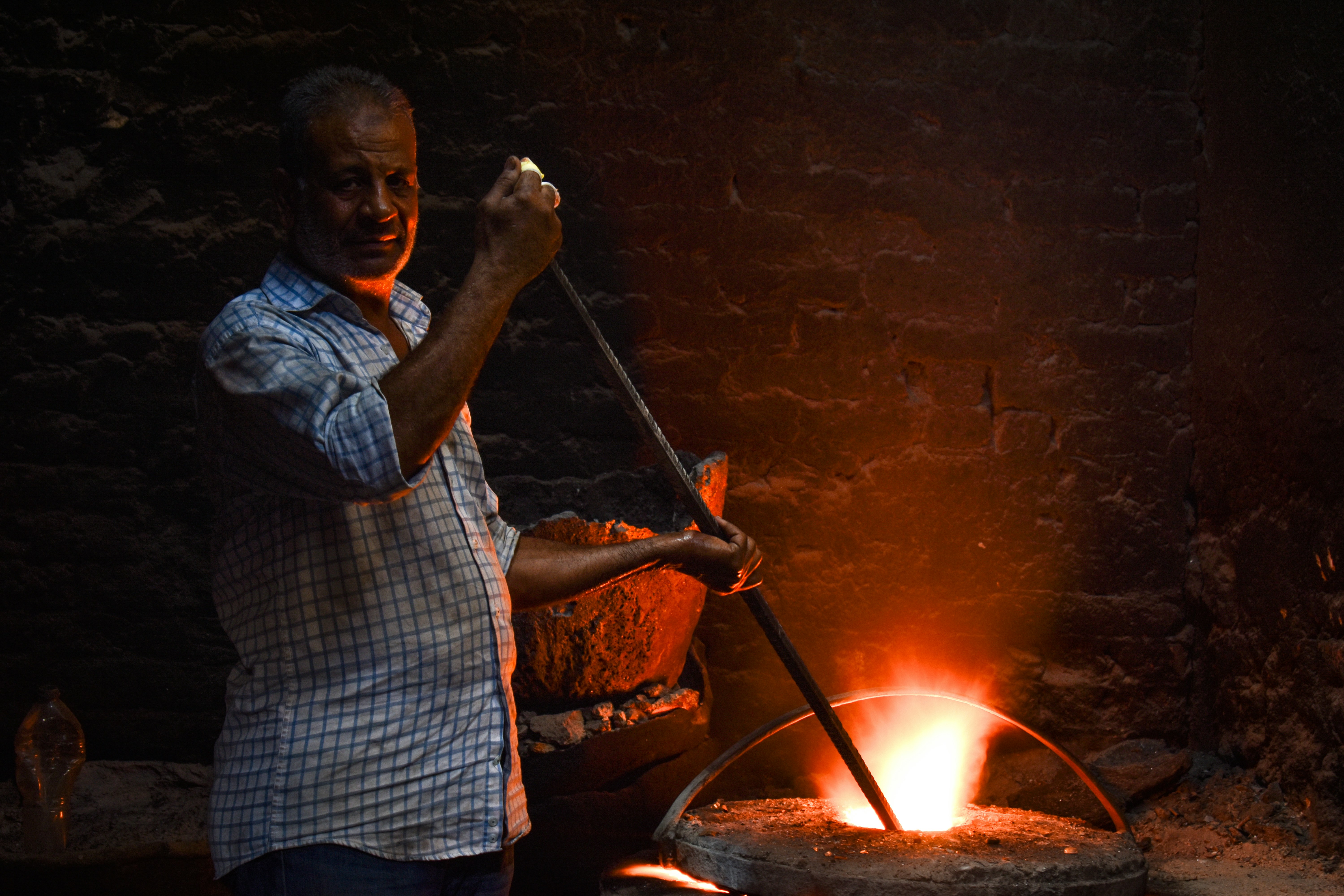 Iron worker | A man works with molten glass.