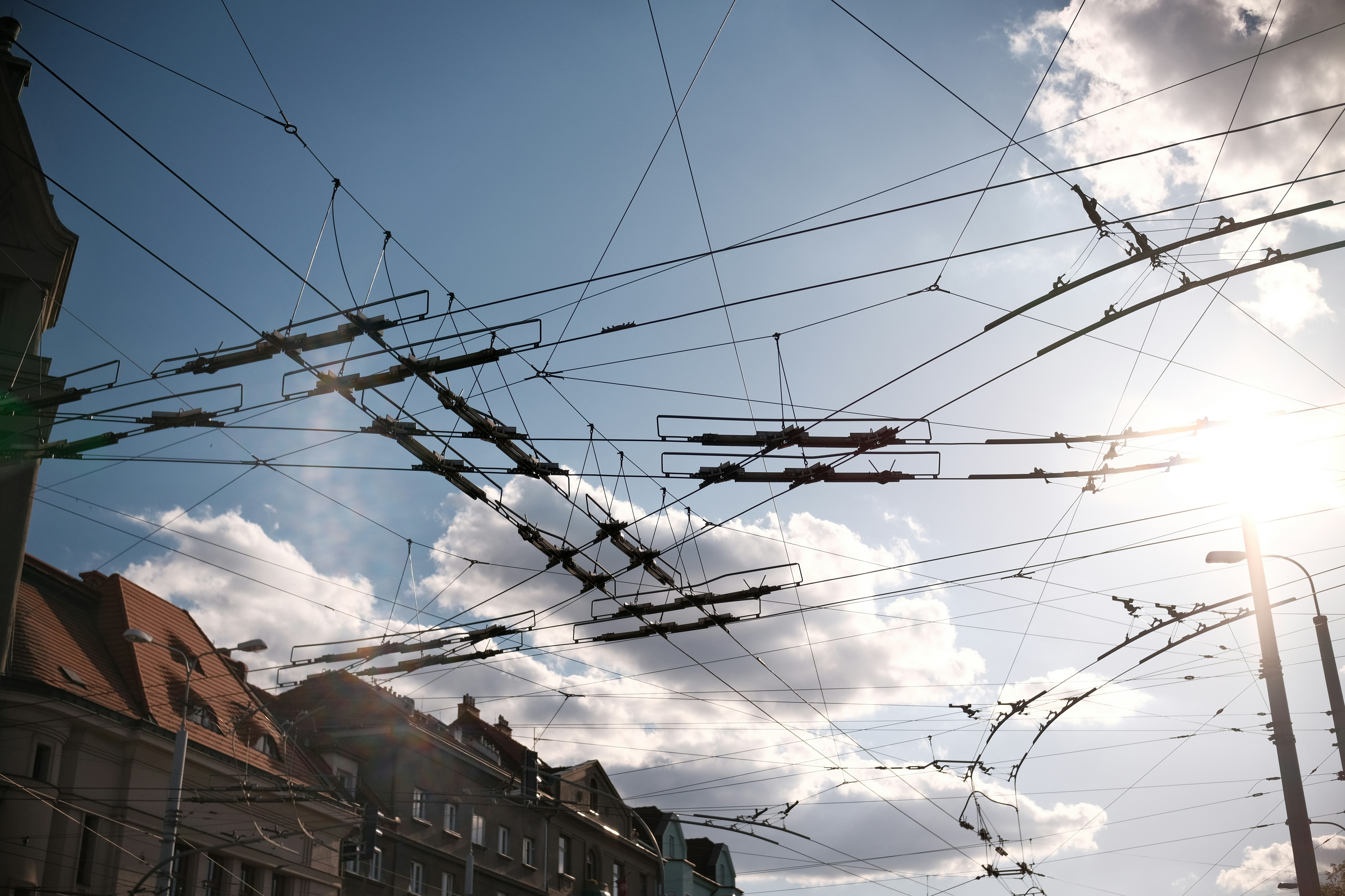 Crisscrossed Sky Wires Over Sunlit Rooftops