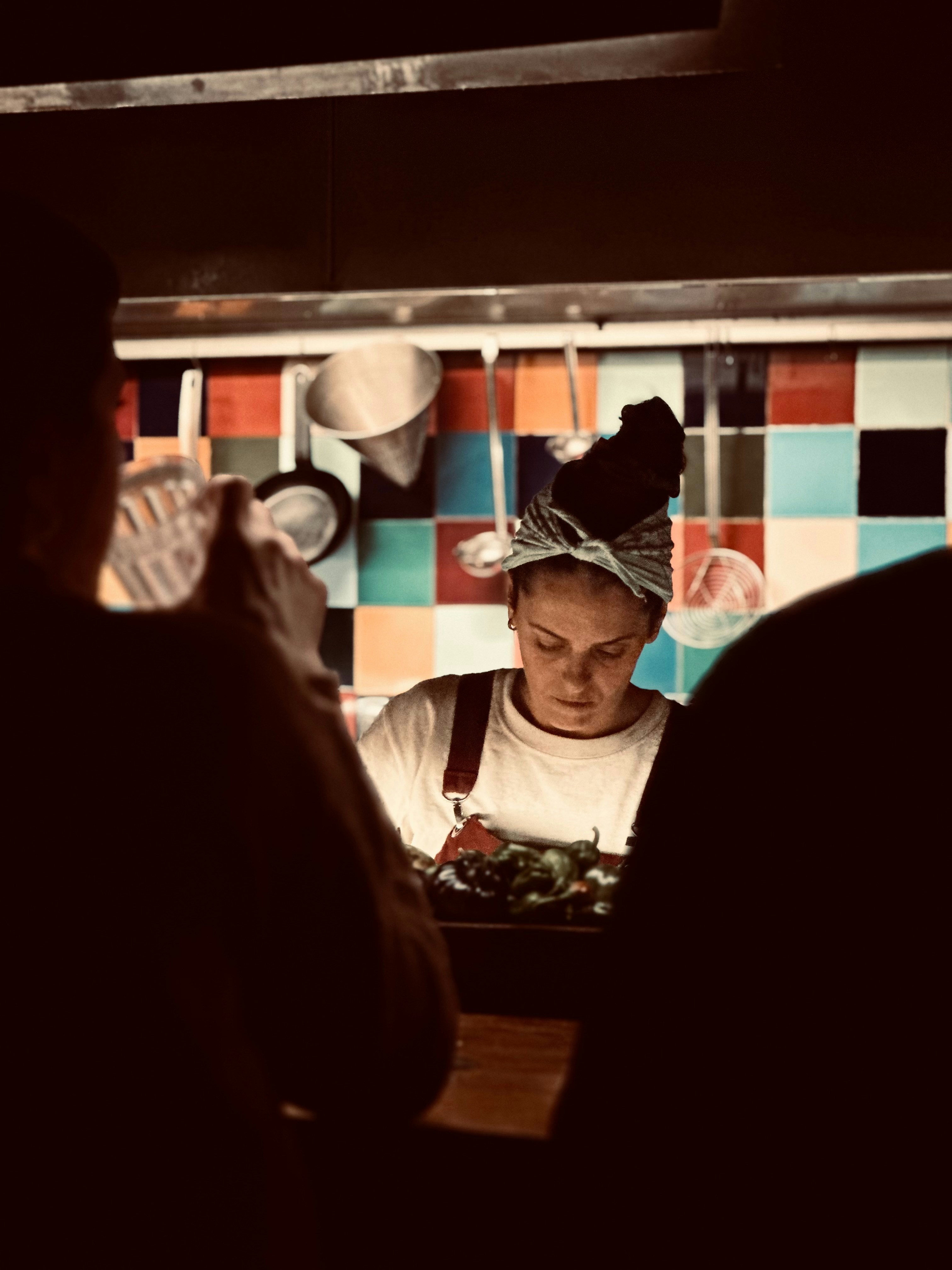 Stovetop Vigil: Chef in Focus Behind Colored Tiles