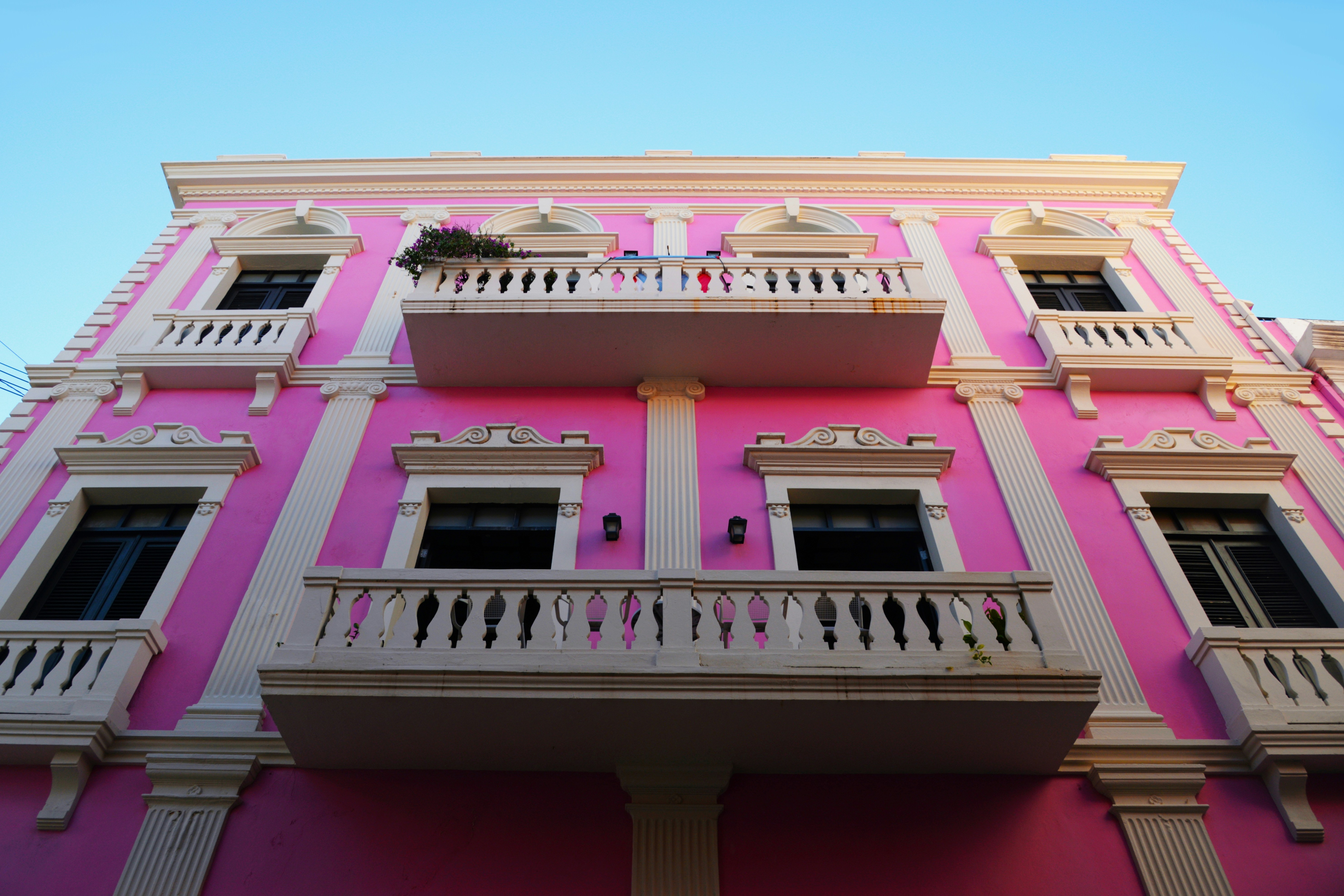 A bright pink building with balconies. photo – Free Building Image on ...