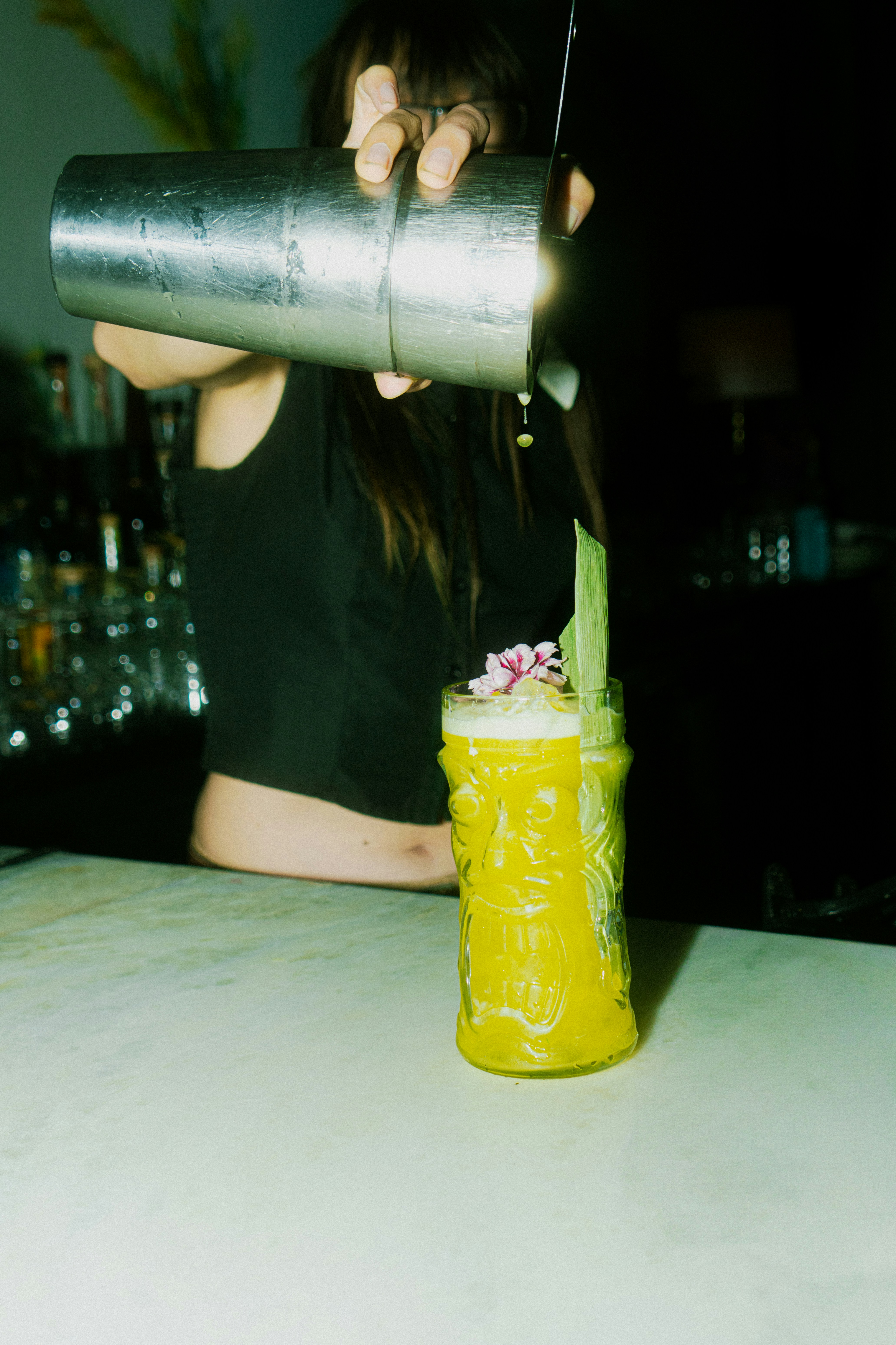 Bartender expertly pours a drink into a tiki glass. photo – Free ...