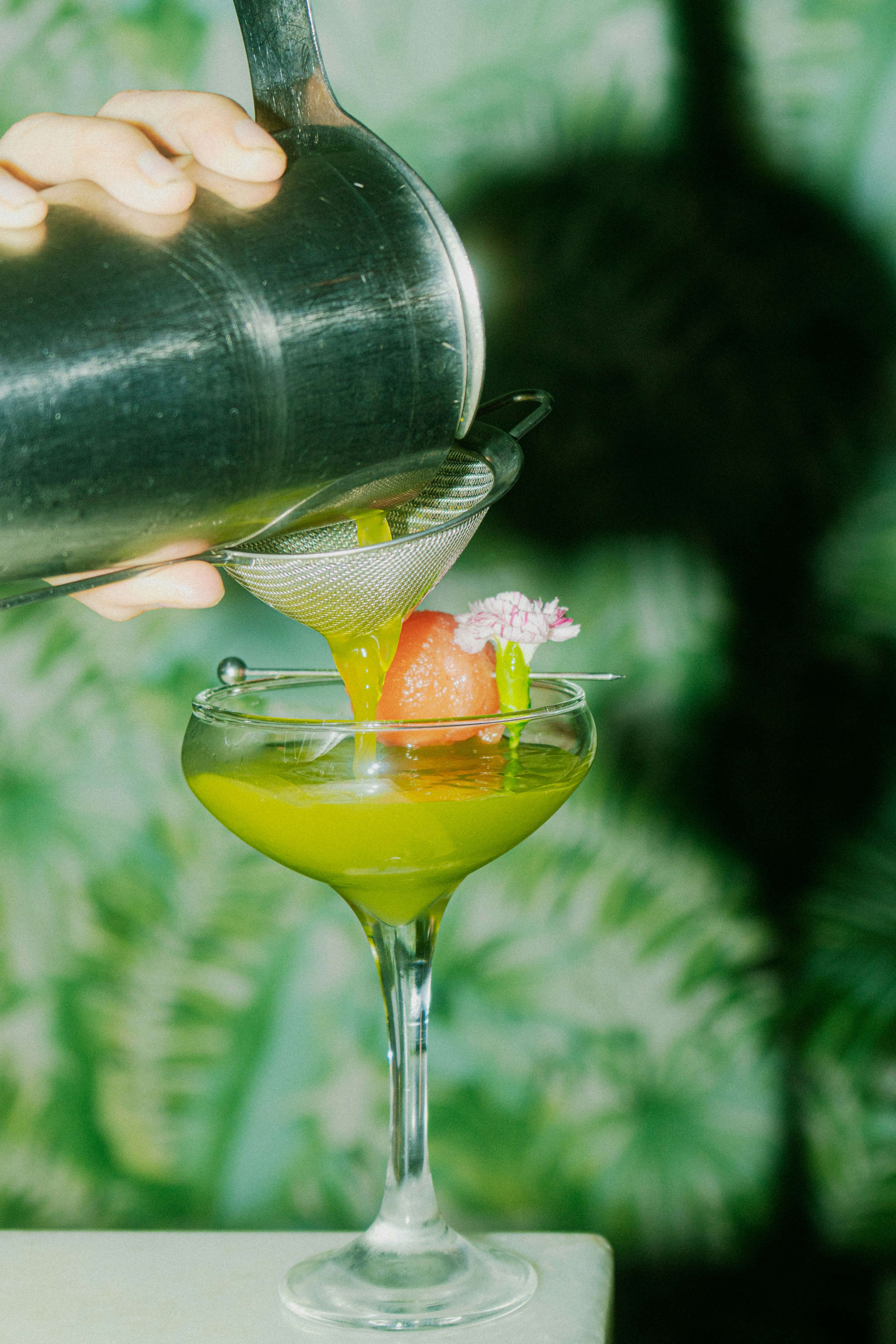 Citrus Cascade: Green Elixir Flows into a Coupe Under Tropical Light