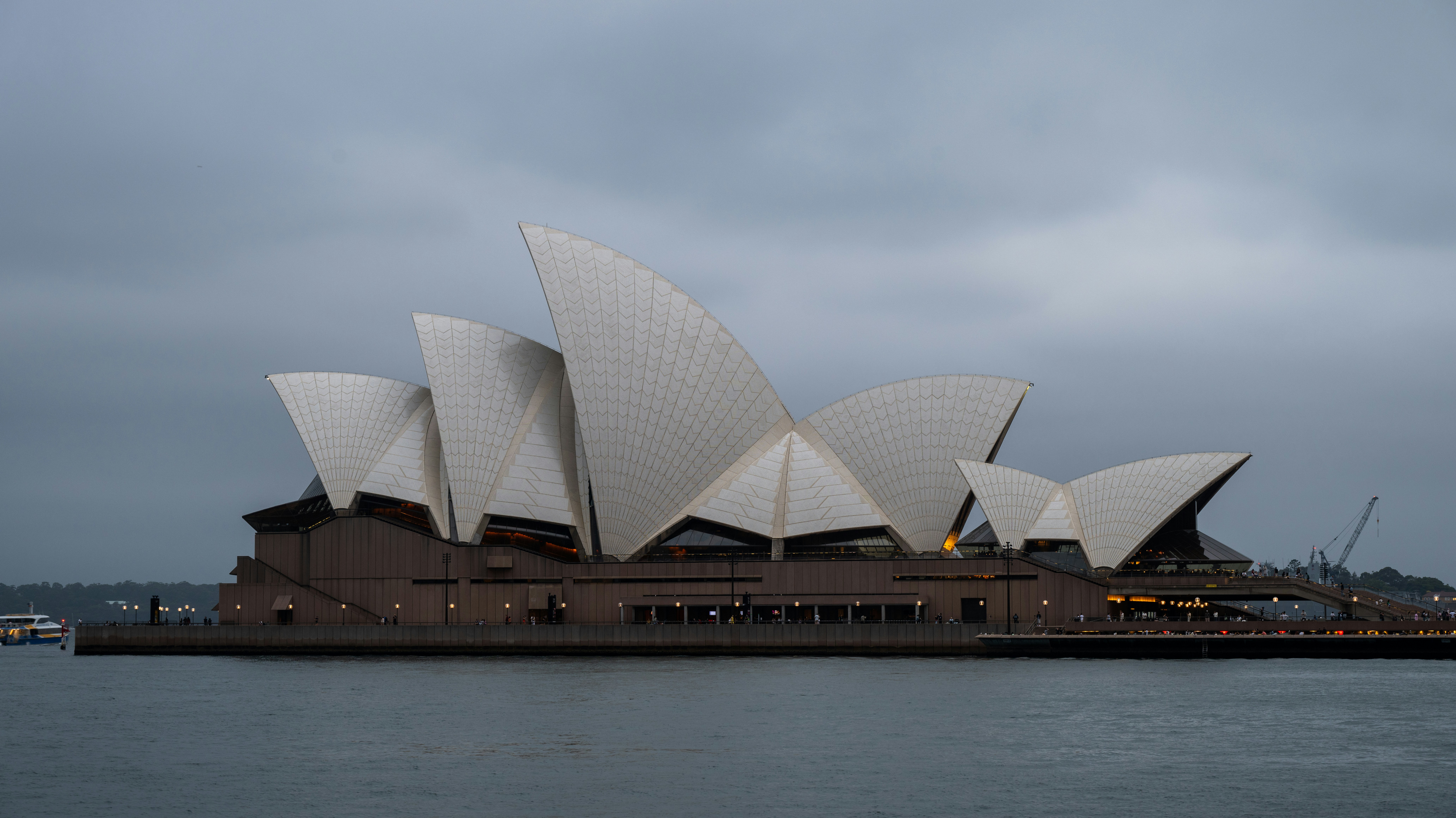 Monochrome Harbor: Sydney Opera House's Sails Stand Against a Clouded Sky
