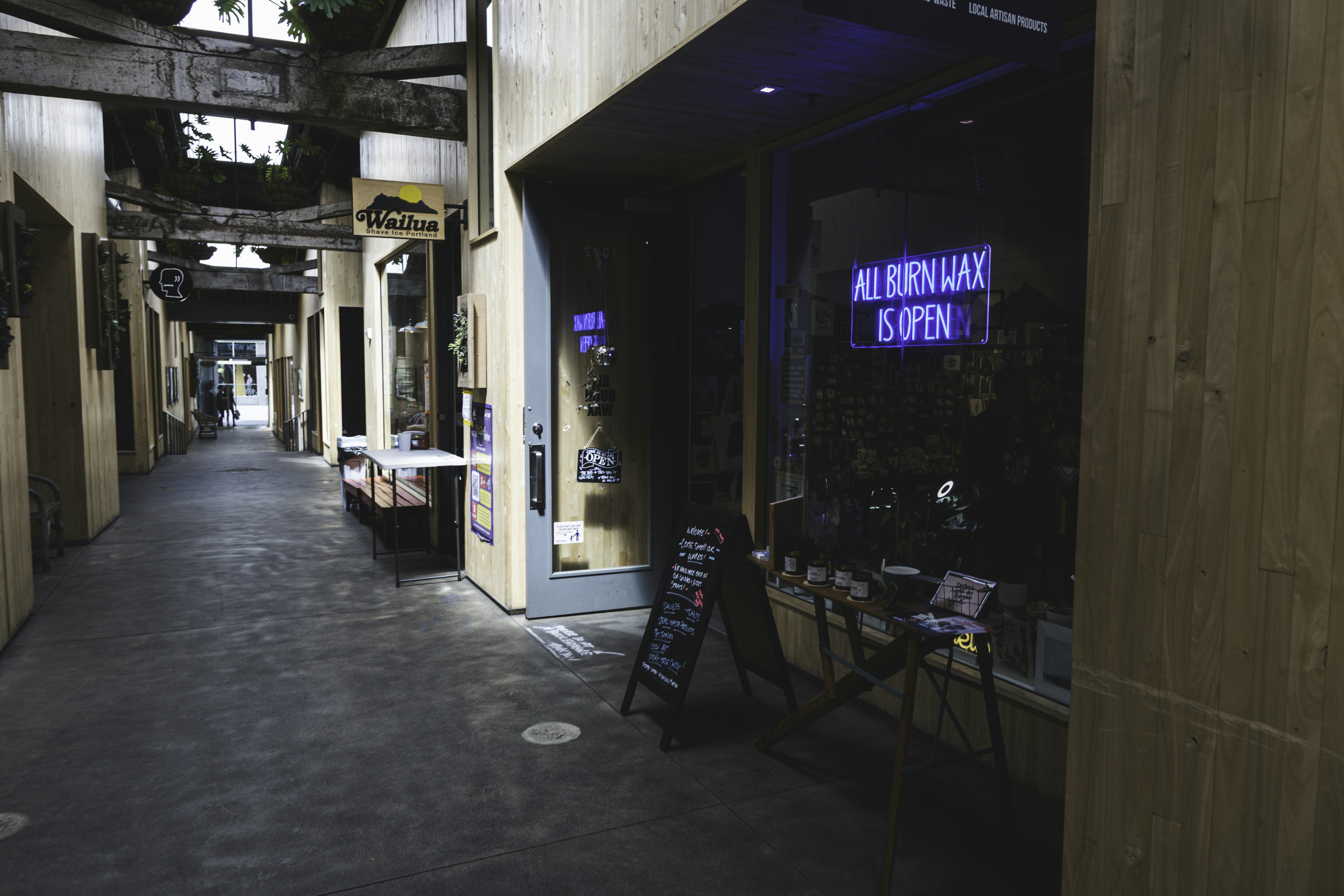 A narrow arcade with a shop displays "open."