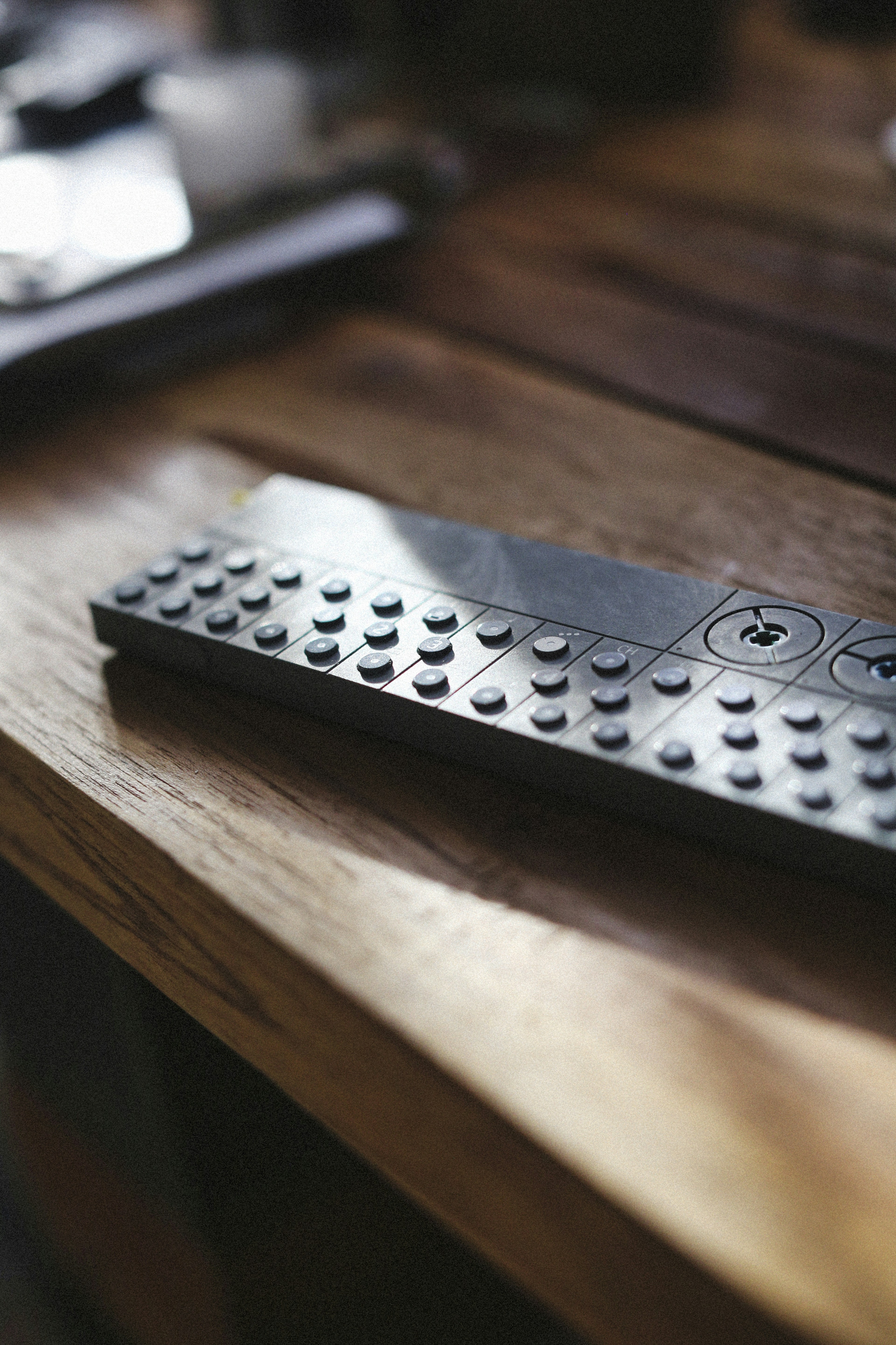 Studded Quietude: A LEGO Brick Remote Resting on Warm Wood