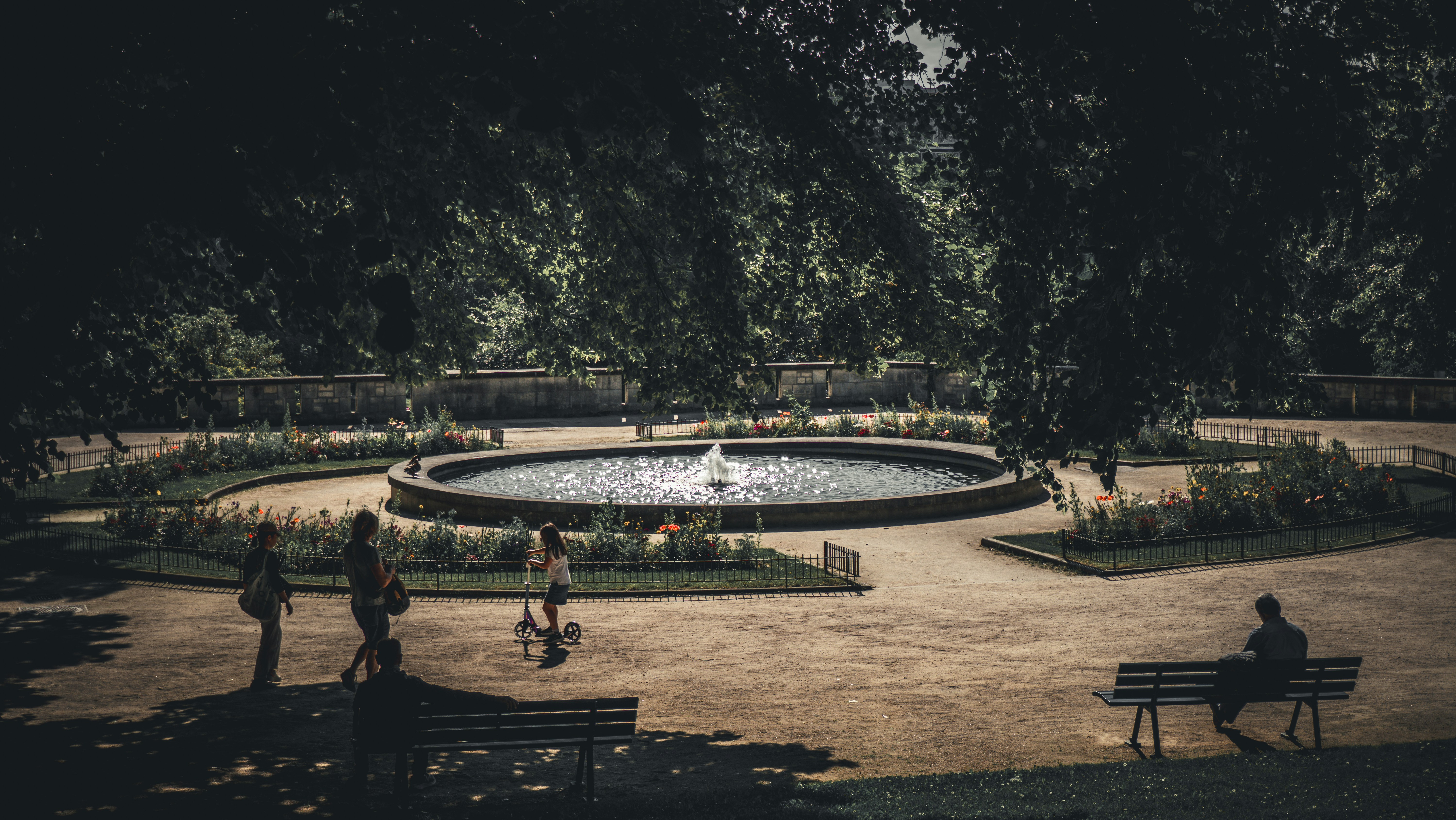 Dappled Light Circles a Tranquil Park Fountain at Dusk