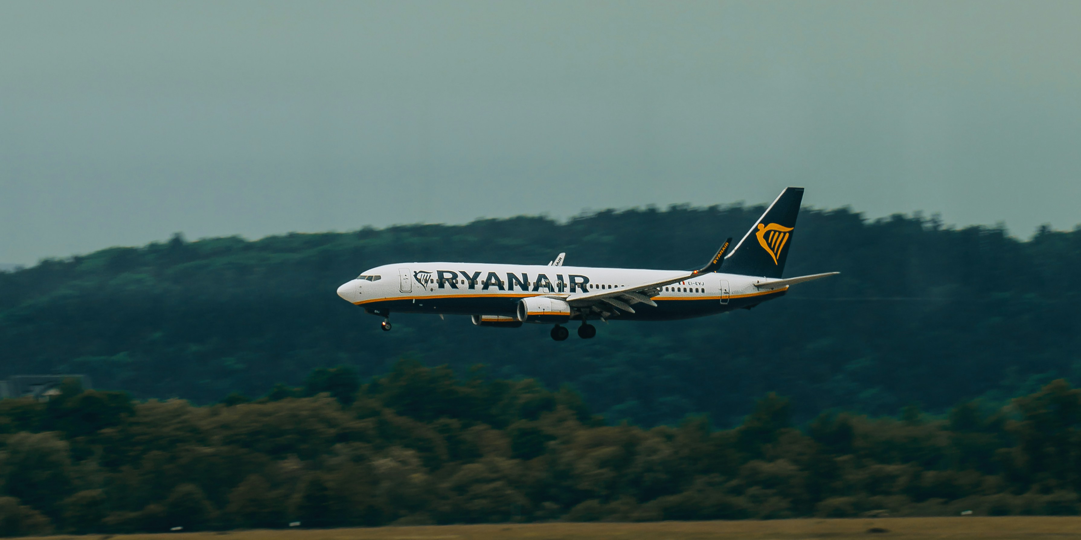 Ryanair on final approach over a forested horizon