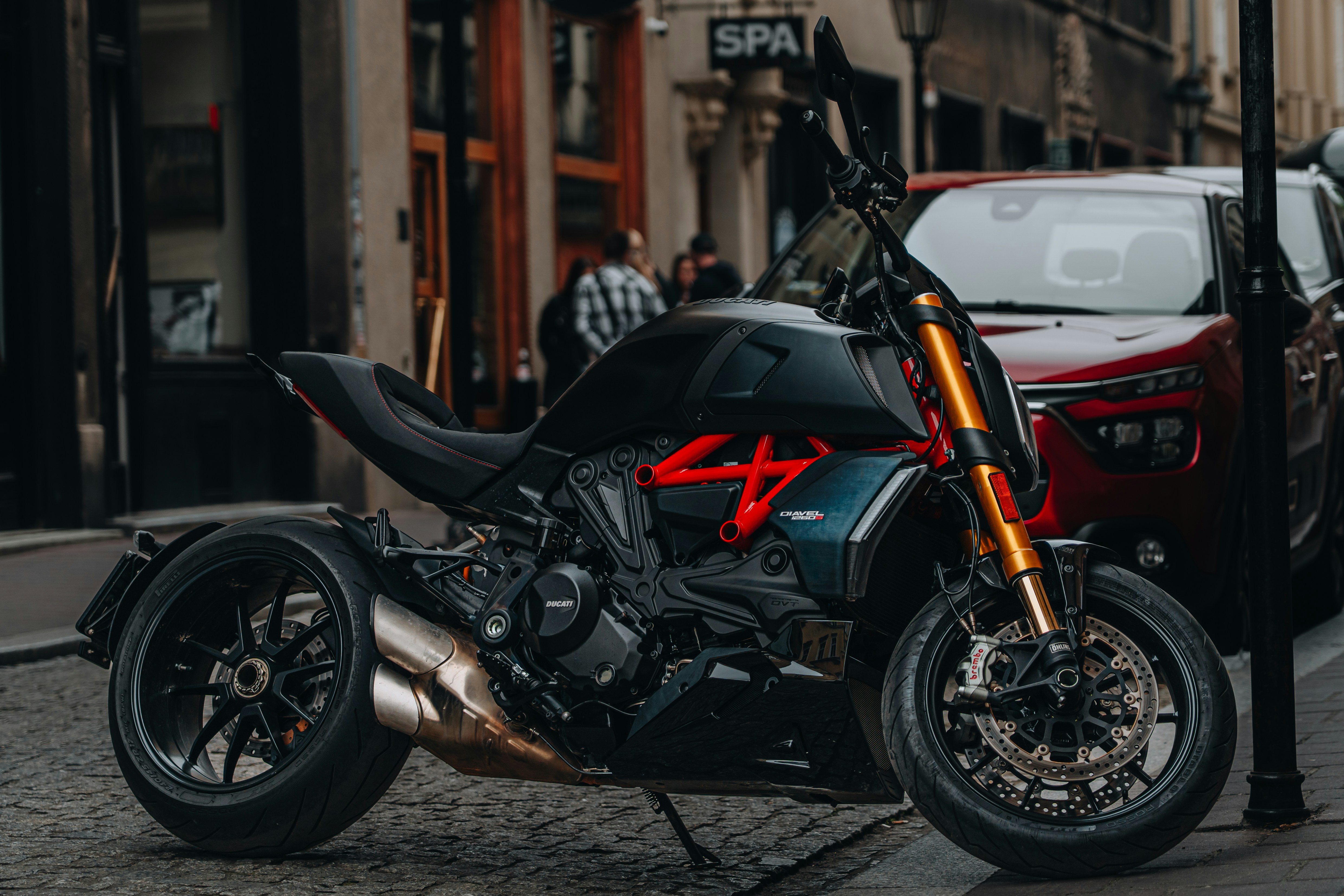 Urban Stallion: Matte-Black Sport Bike with Red Frame on Cobblestone Street