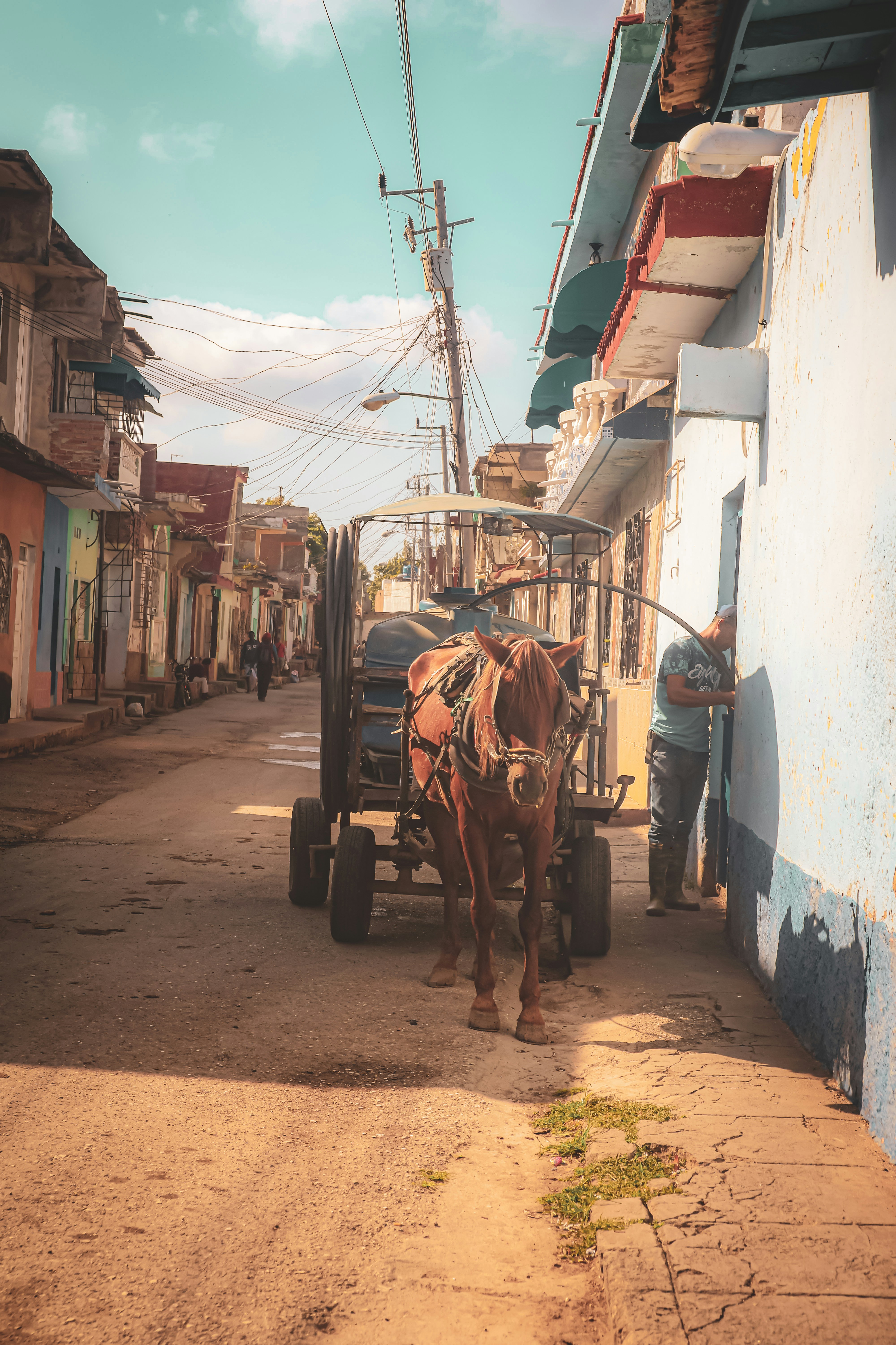 Horse-drawn carriage parked on a narrow cobblestone street.