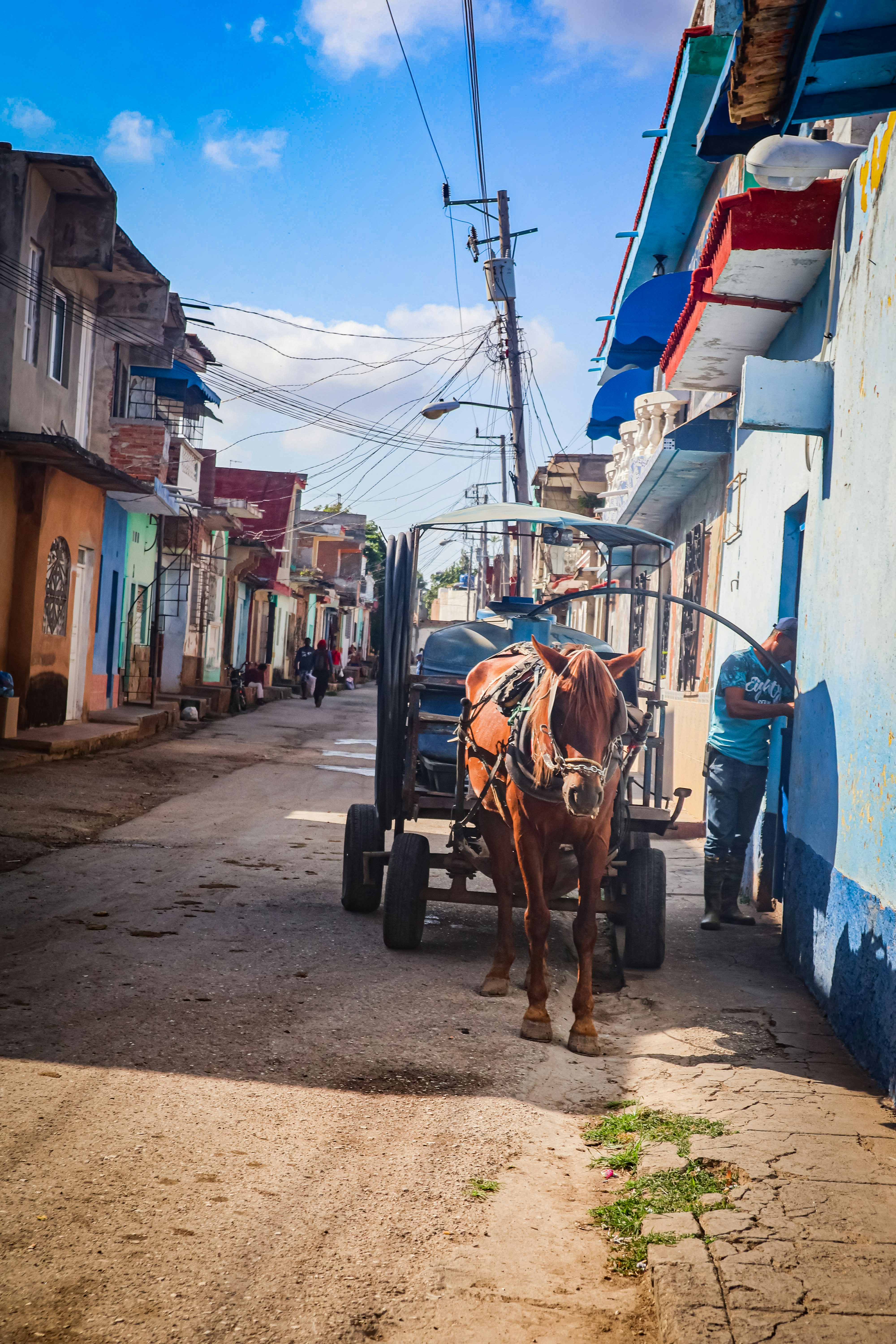 Sunlit Street Carriage Through a Colorful Coastal Alley