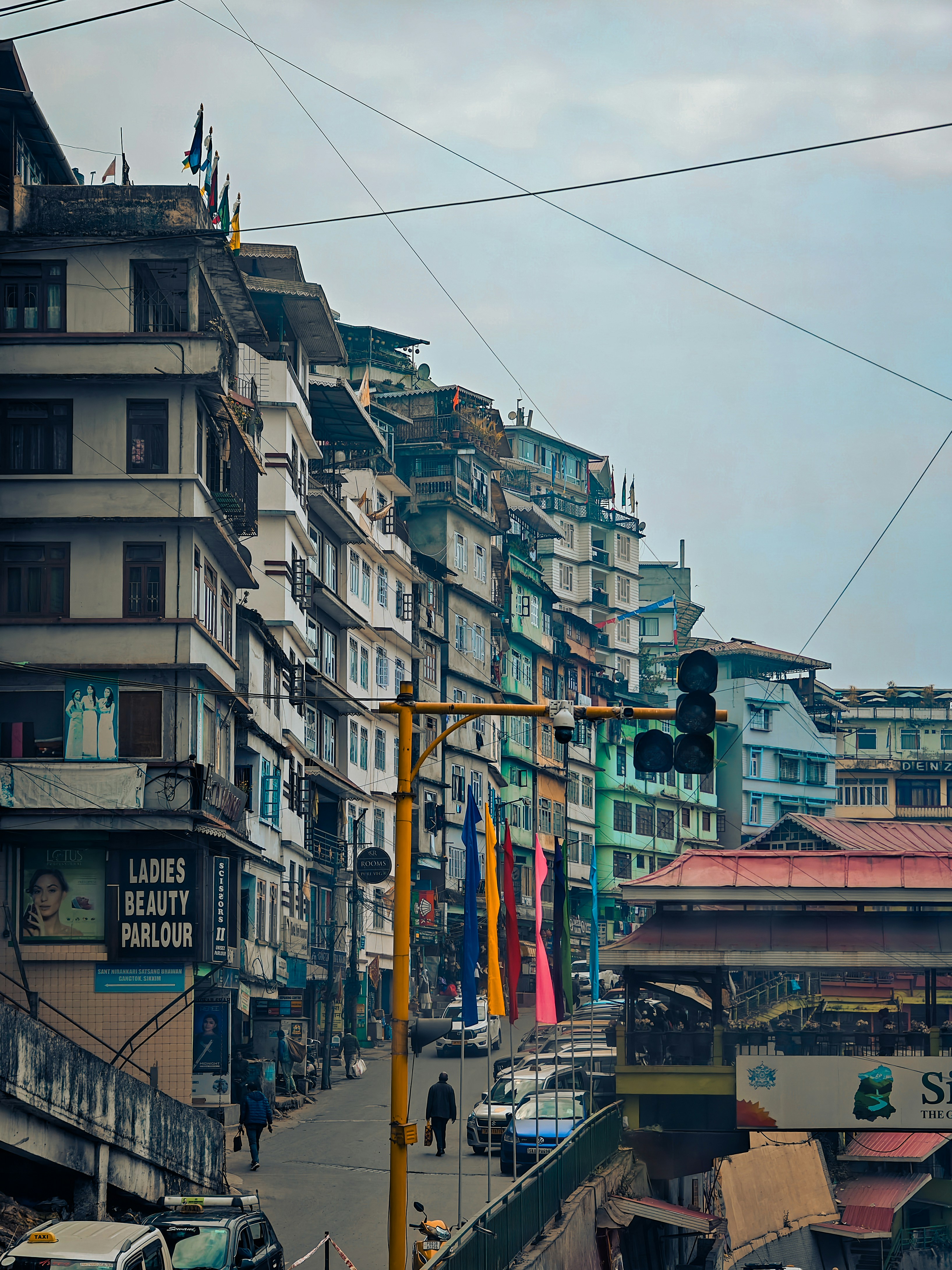 Buildings line a street in a bustling city.