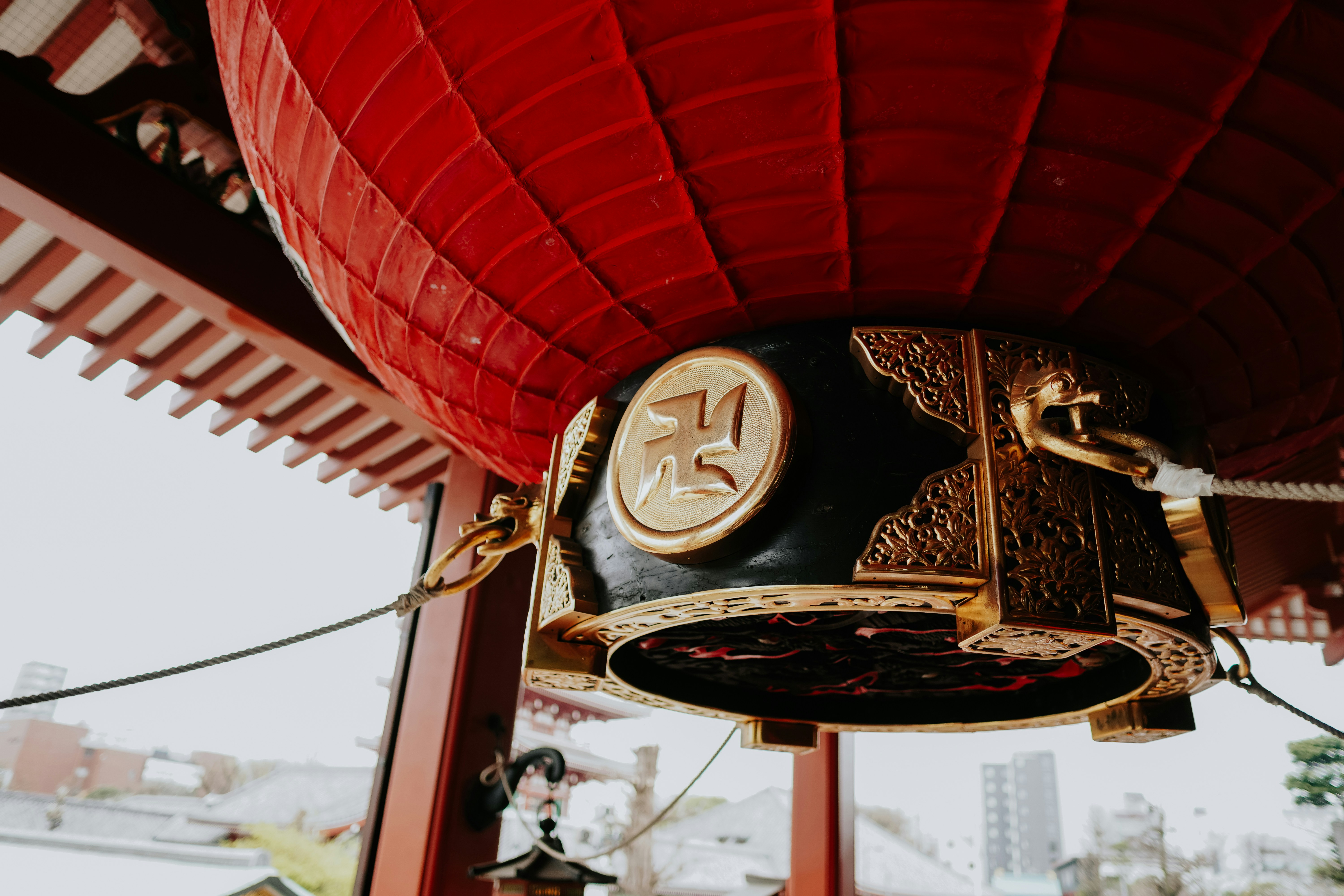Crimson Lantern Over Ornate Bell: A Temple's Quiet Metallic Echo