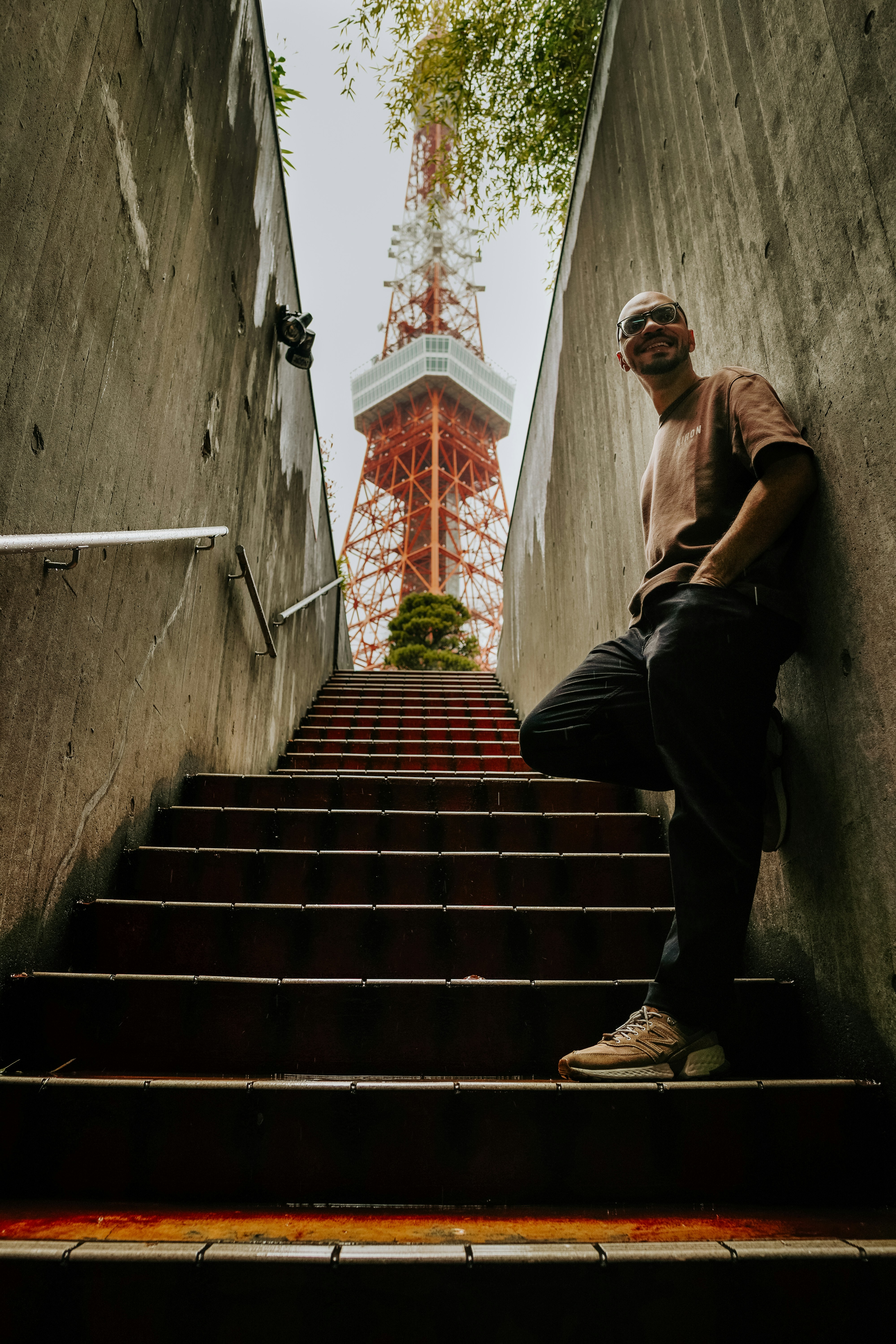 Man poses near tokyo tower.