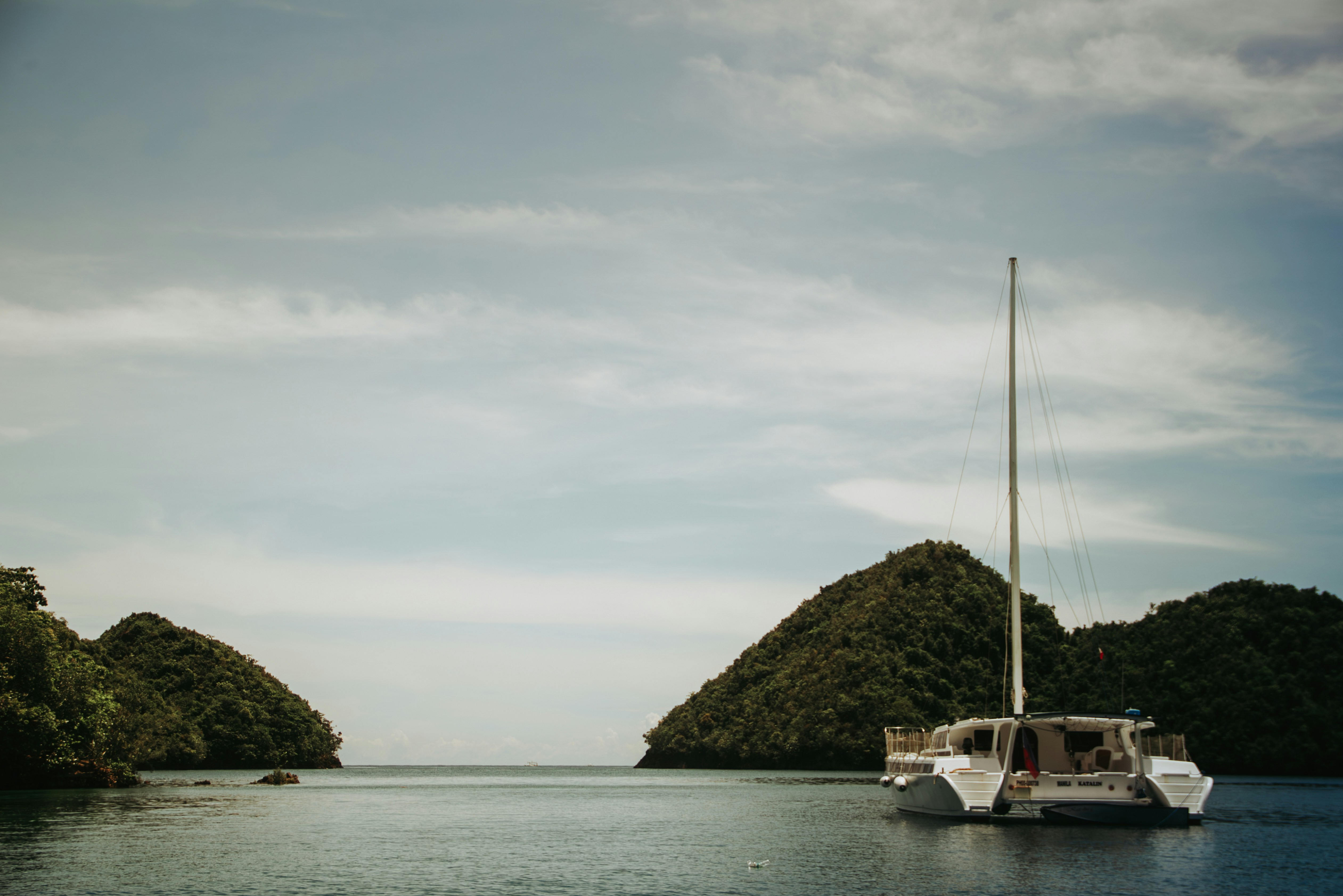 Lone Sailboat Anchored Between Emerald Islets in a Calm Sea