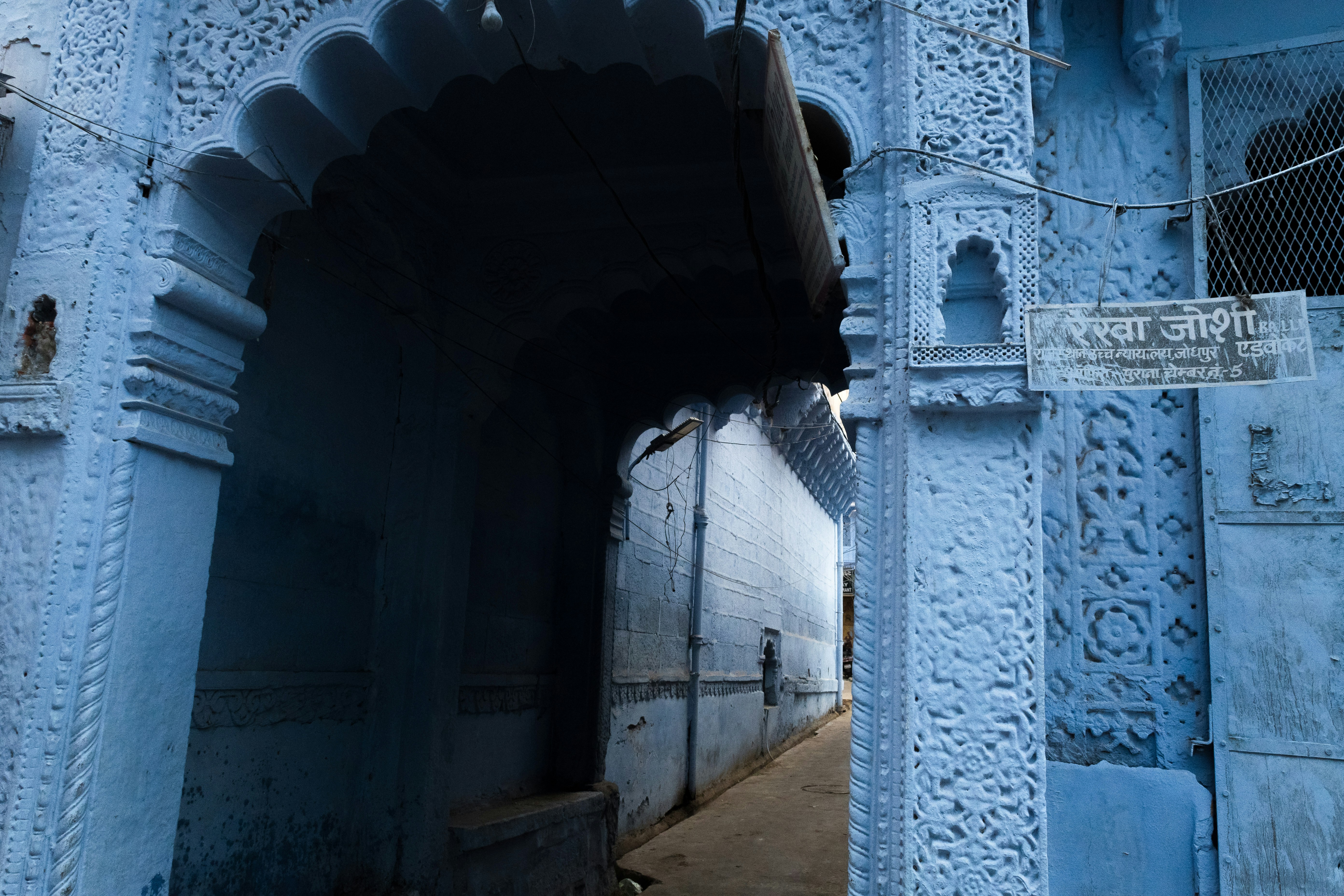 A blue archway leads into a narrow alley. photo – Free Image on Unsplash