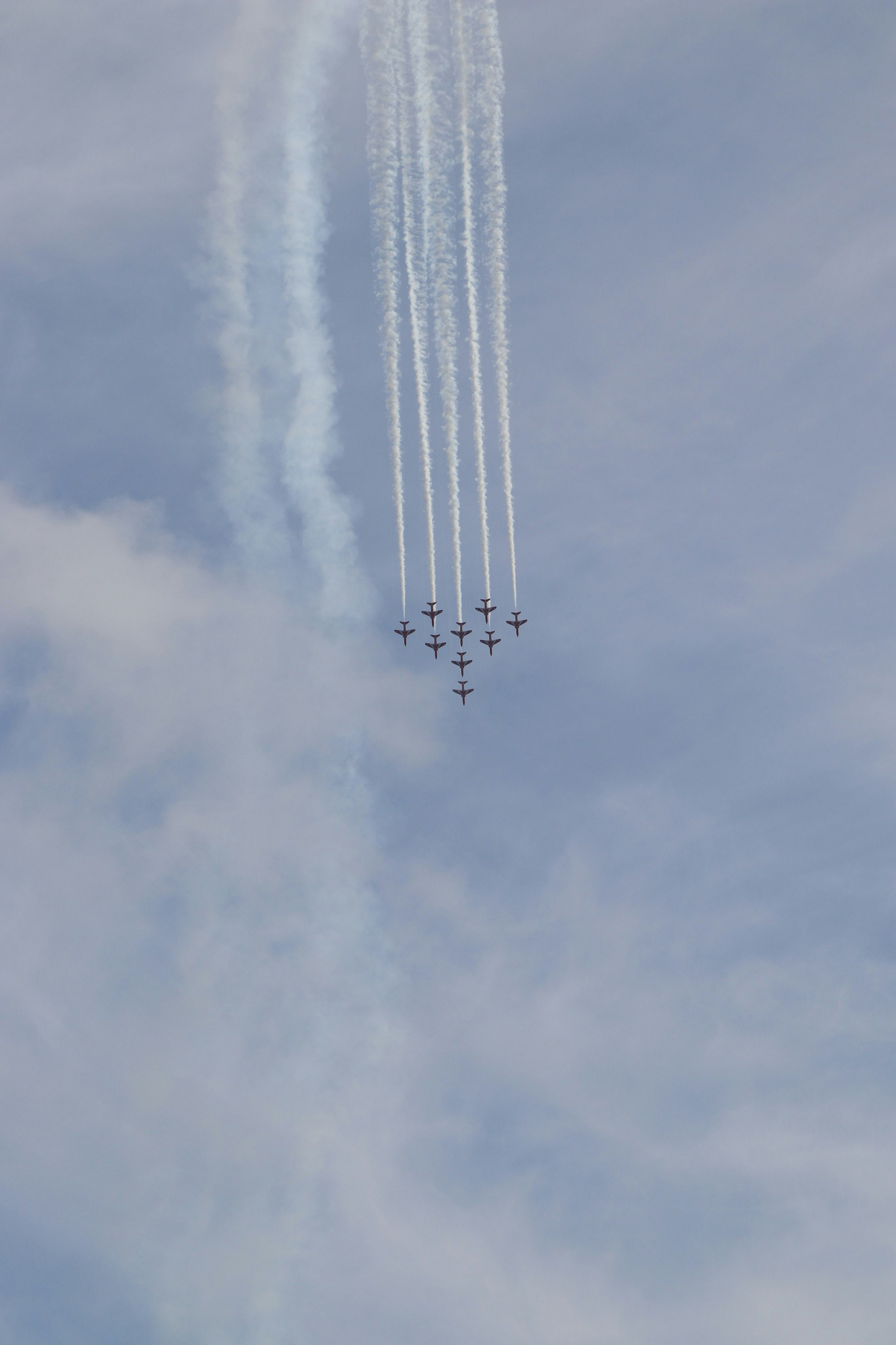 Nine-Jet Formation Traces White Lines Across a Calm Blue Sky