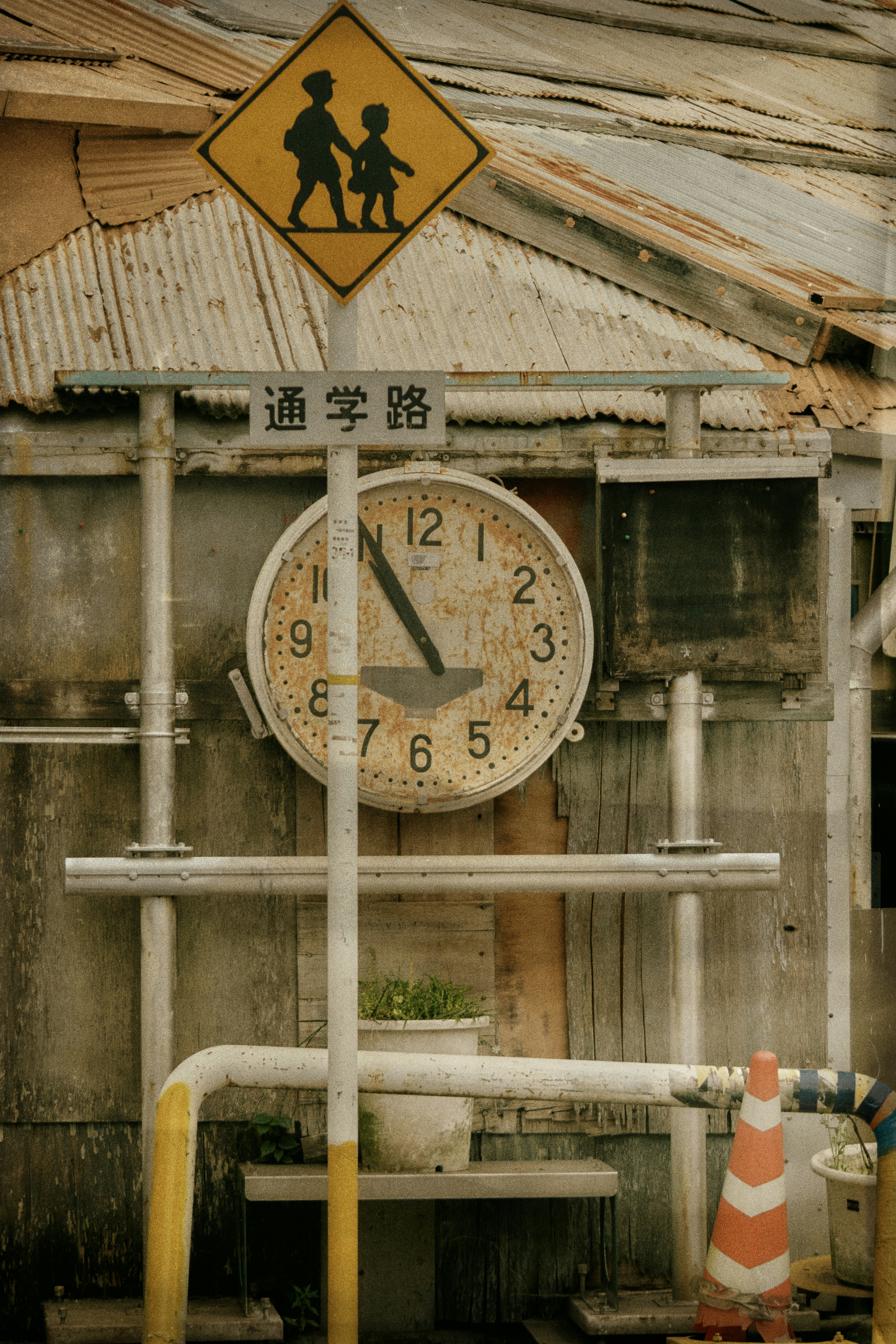 Rust-Clock Junction: An Aged Timepiece Beneath a Pedestrian Sign in an Industrial Nook