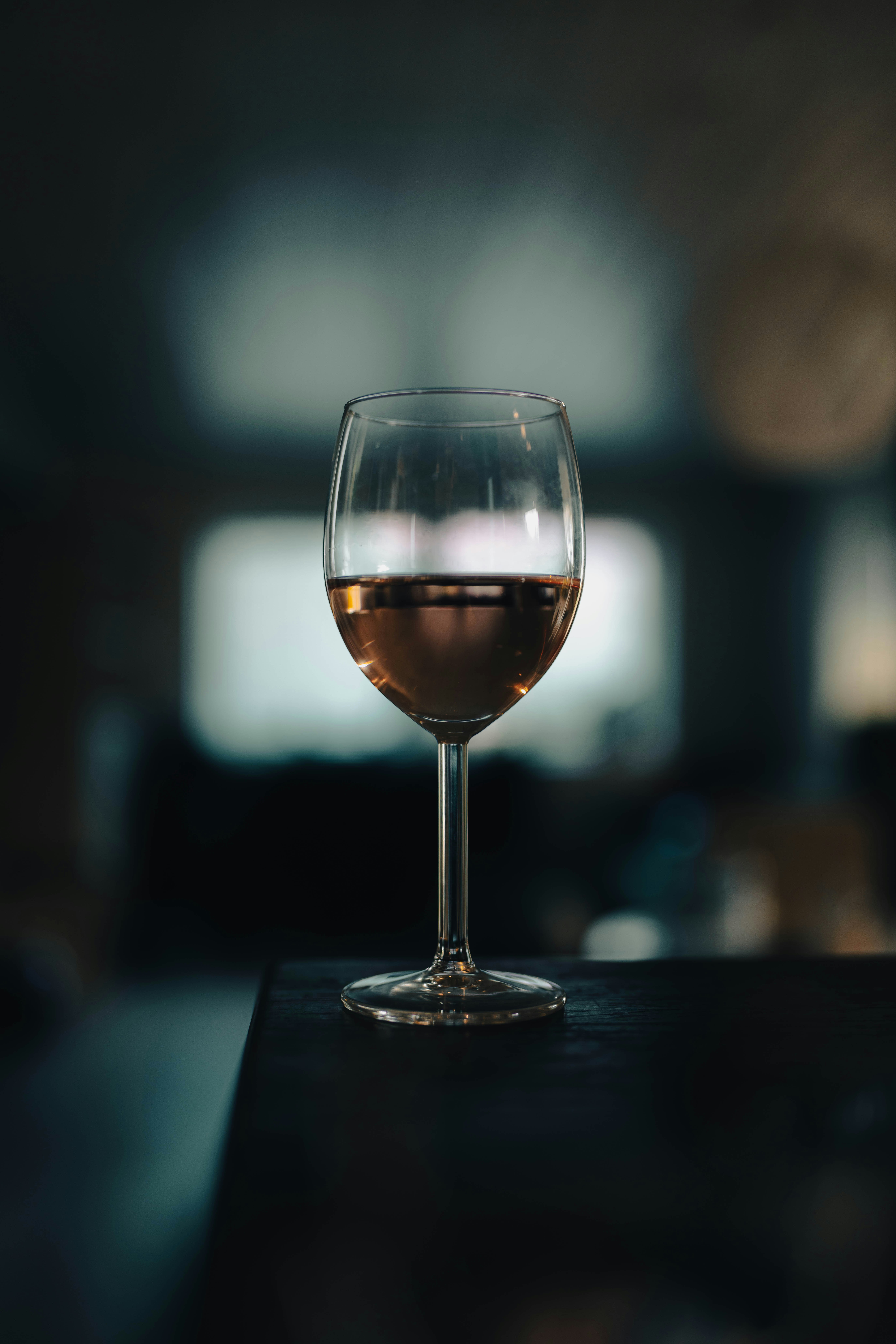 A glass of wine sits centered on a table.