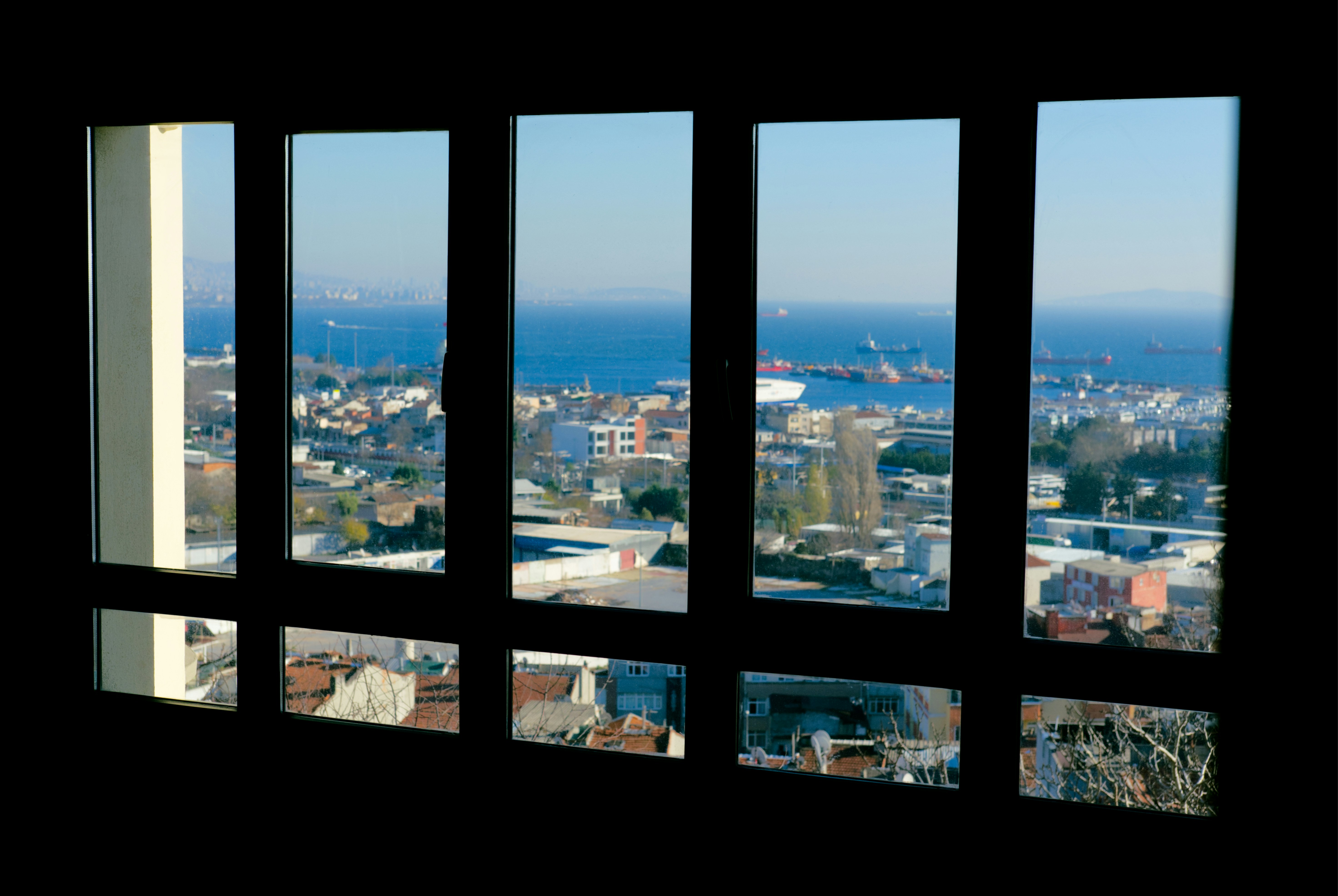 Framed Horizon: Coastal City Through a Window Grid
