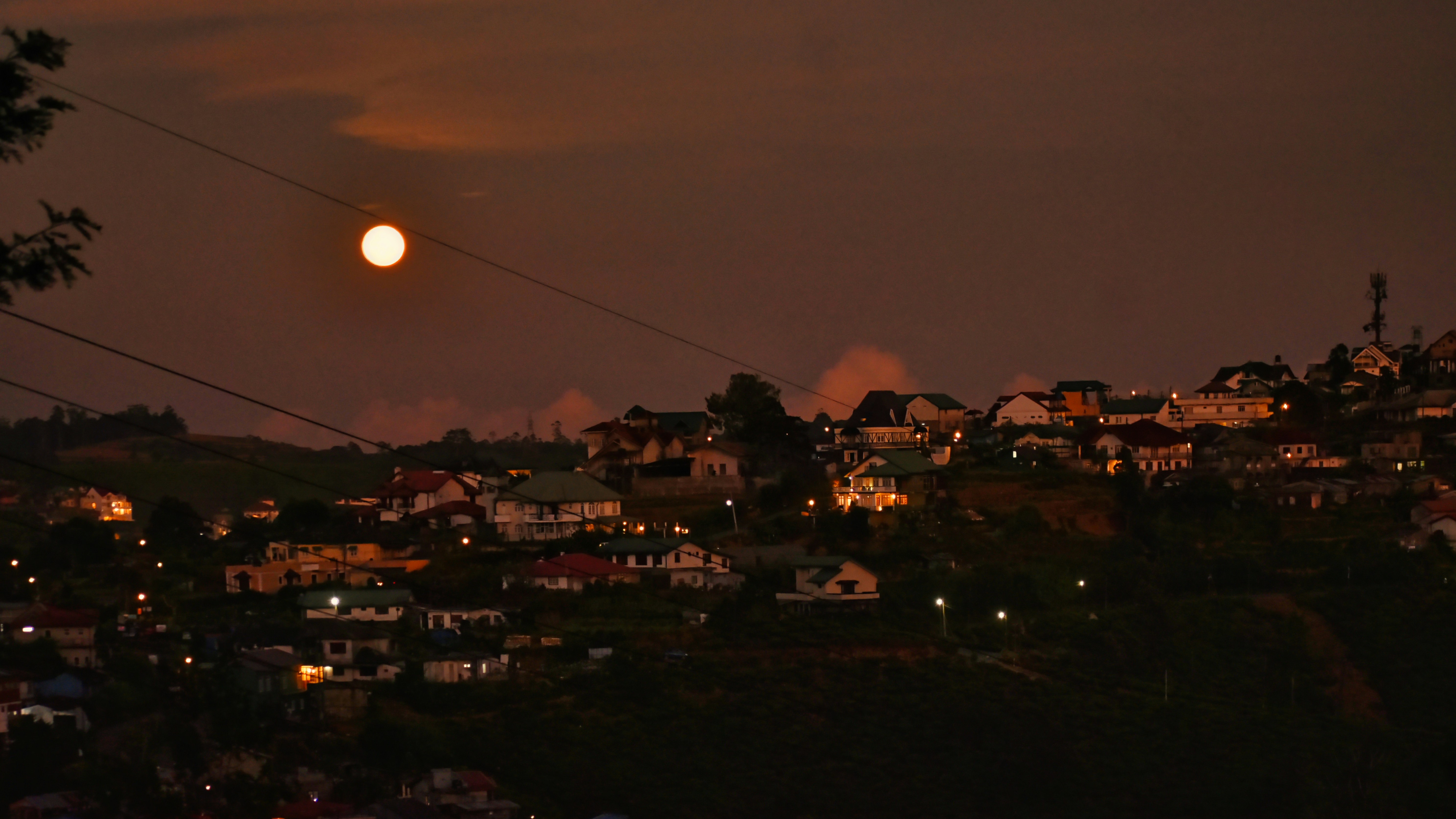 The full moon shines over a peaceful town.