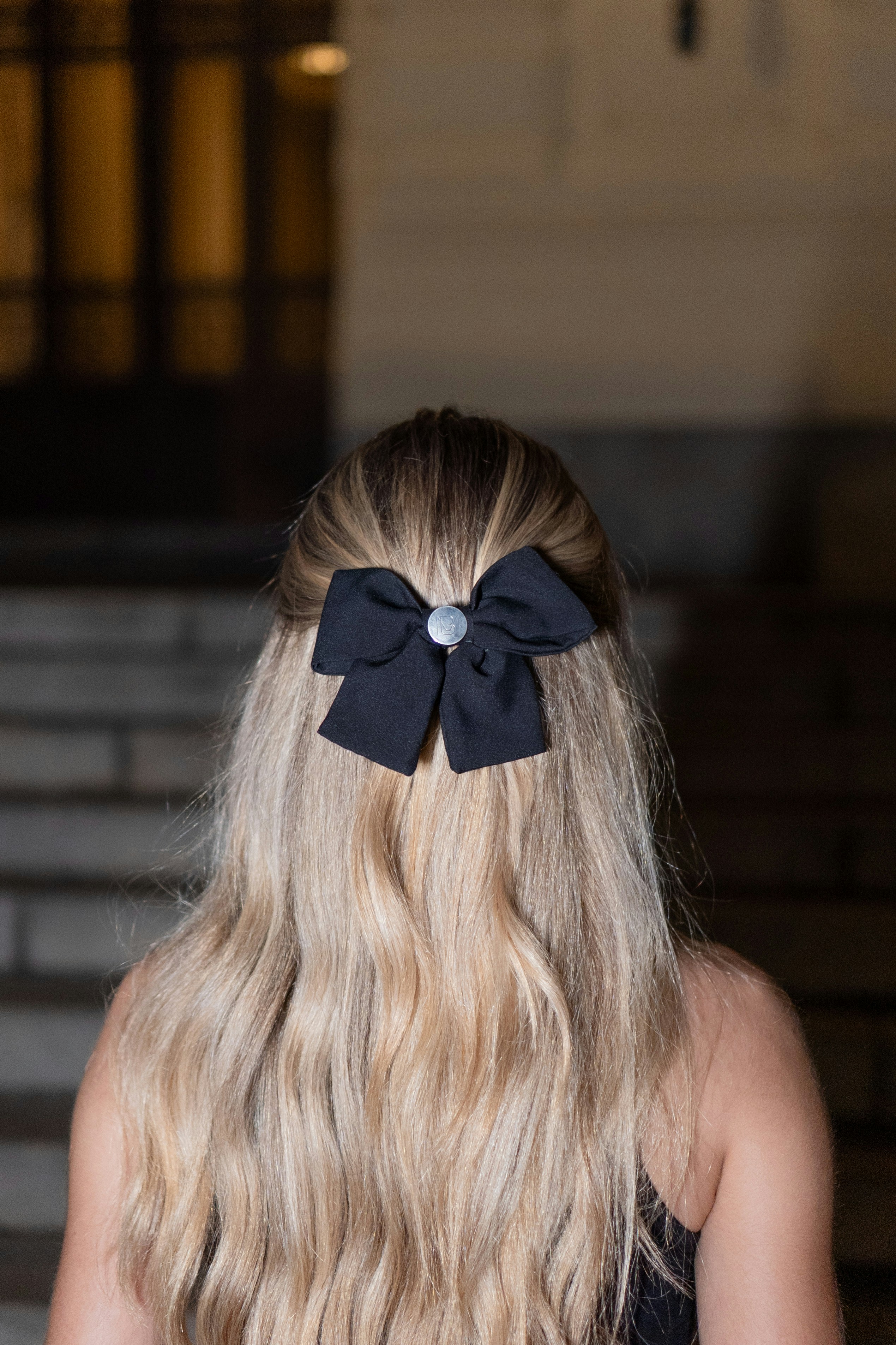 Blonde tied at the crown: a satin bow anchors the night steps