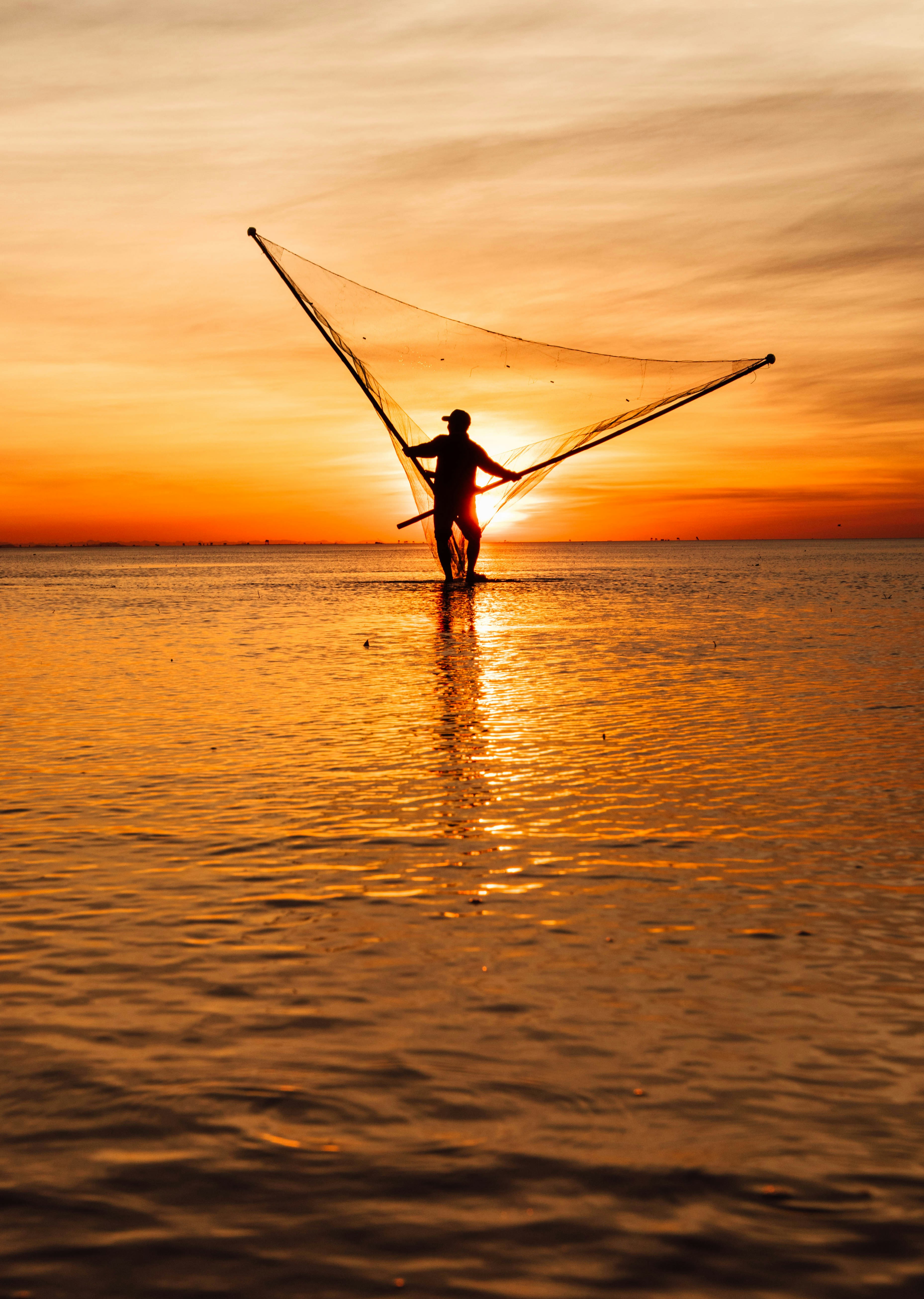 Fisherman casting a net at sunset. photo – Free Man Image on Unsplash
