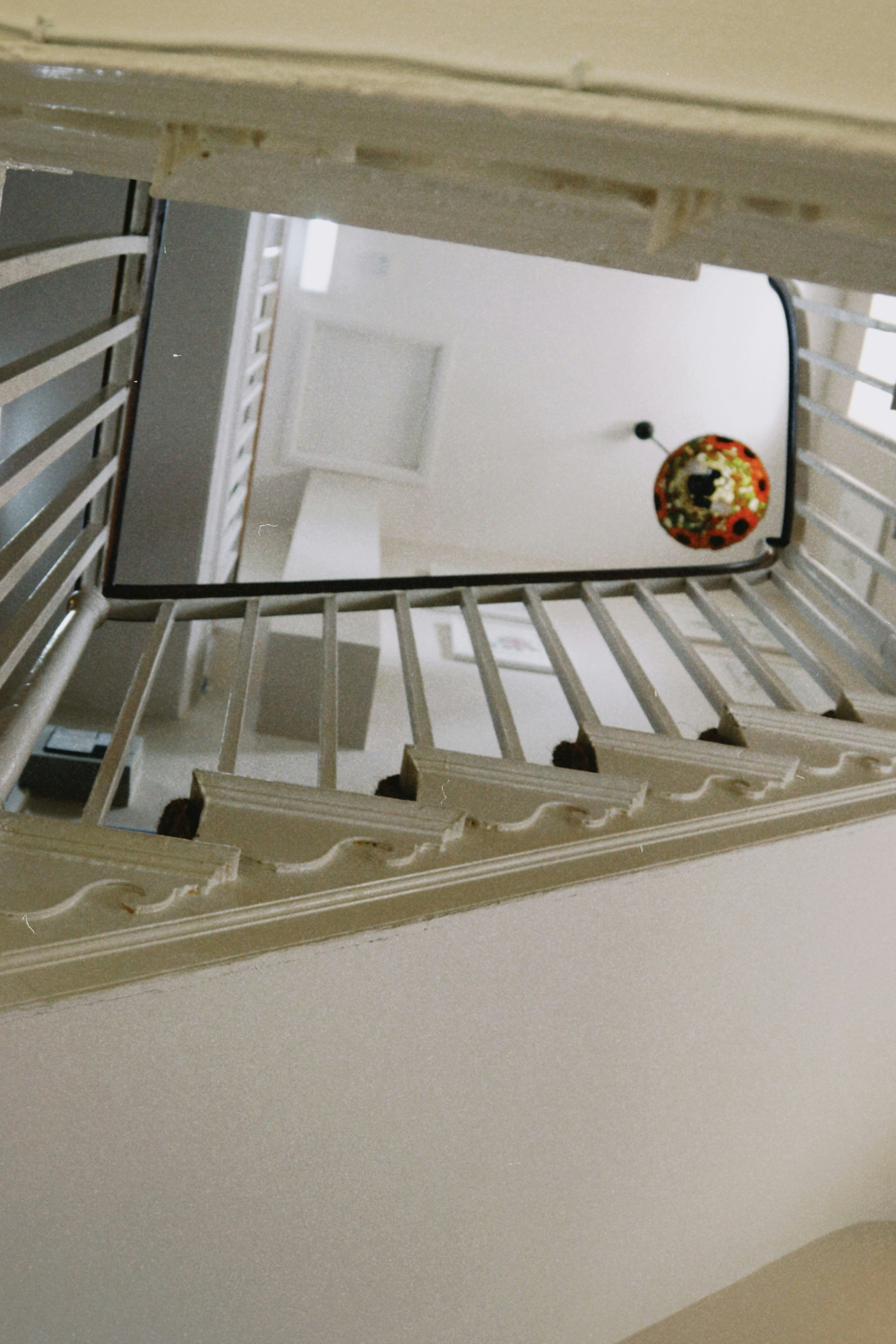 Orb on the Landing: An Orange Accent in a White Stairwell