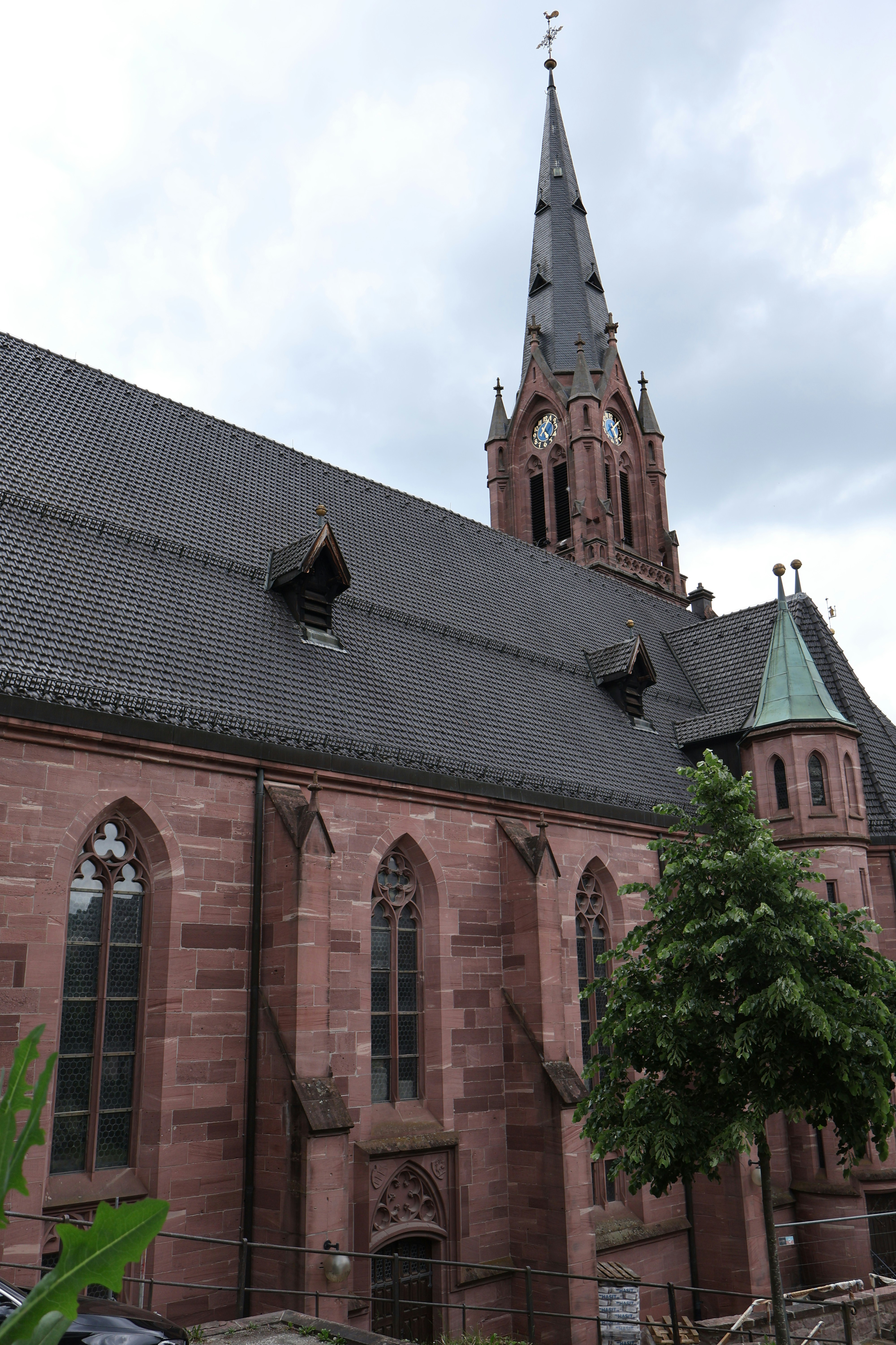 Spire Above Red Brick: A Gothic Church Reaching Into a Cloudy Sky
